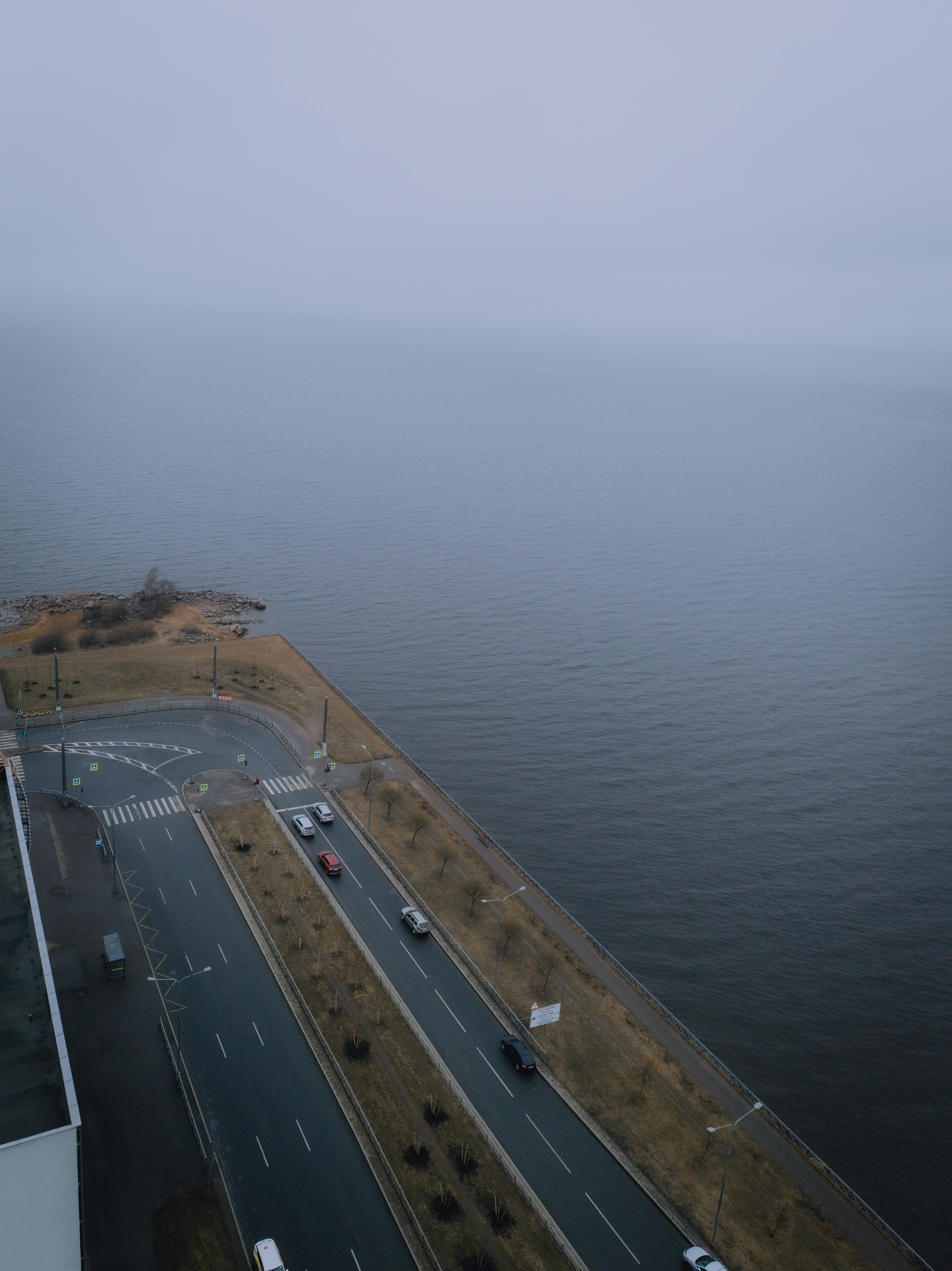 Coastal Courier: Aerial View over a Quiet Waterfront Road