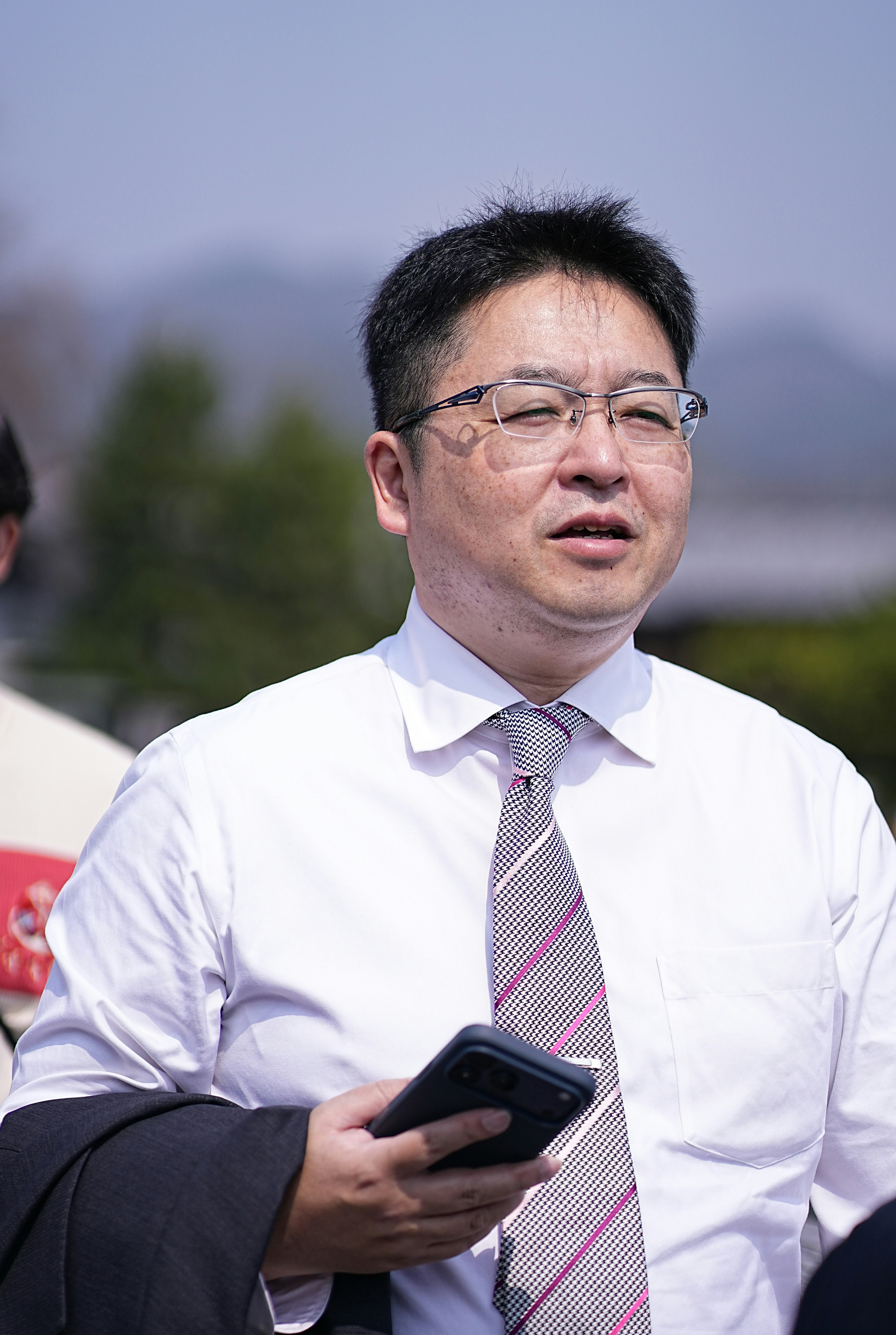 Portrait in Focus: The Presenter with Glasses and Smartphone