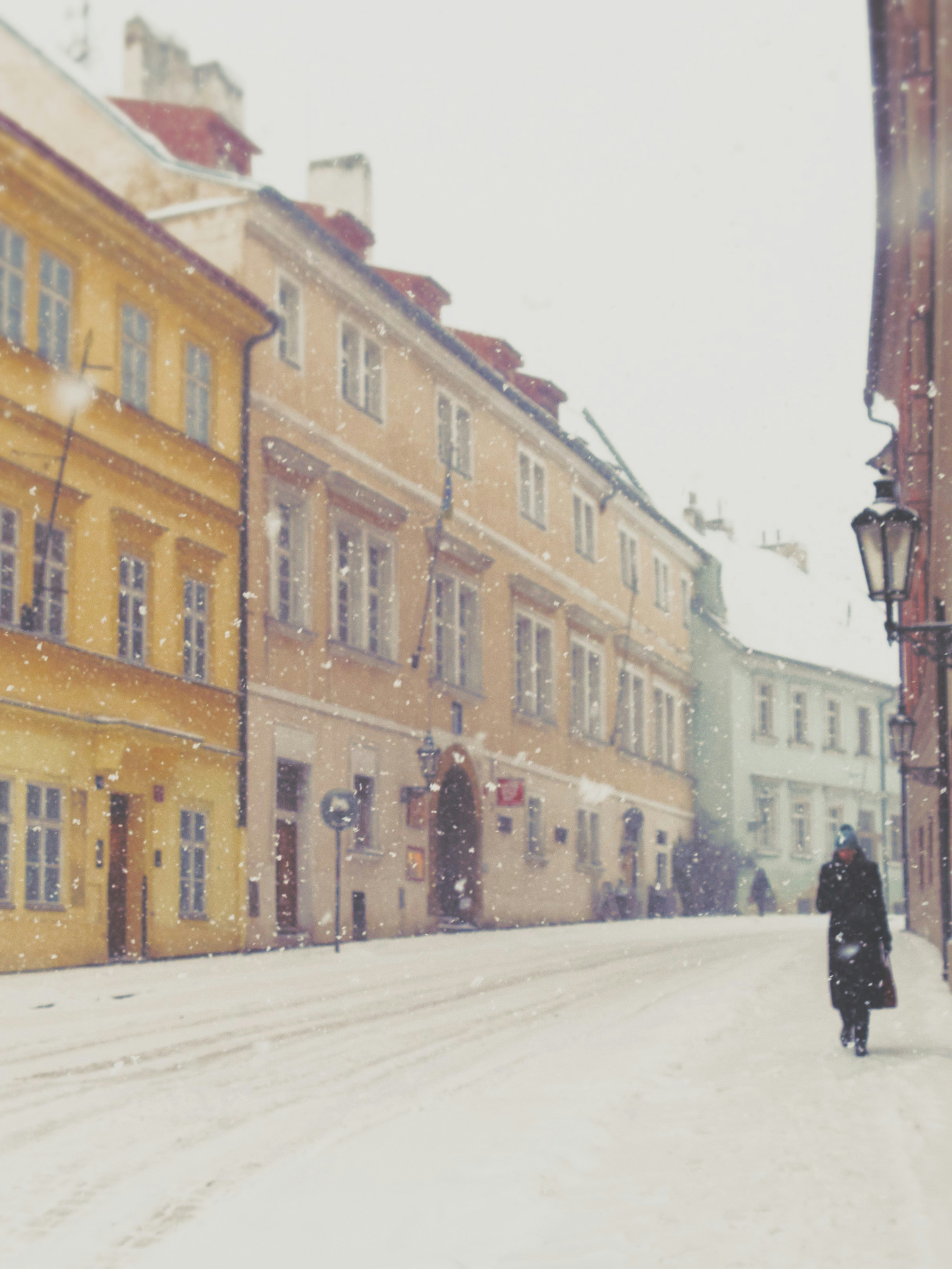 Snowy Baltic Street: Quiet Walk Amid Yellow Facades