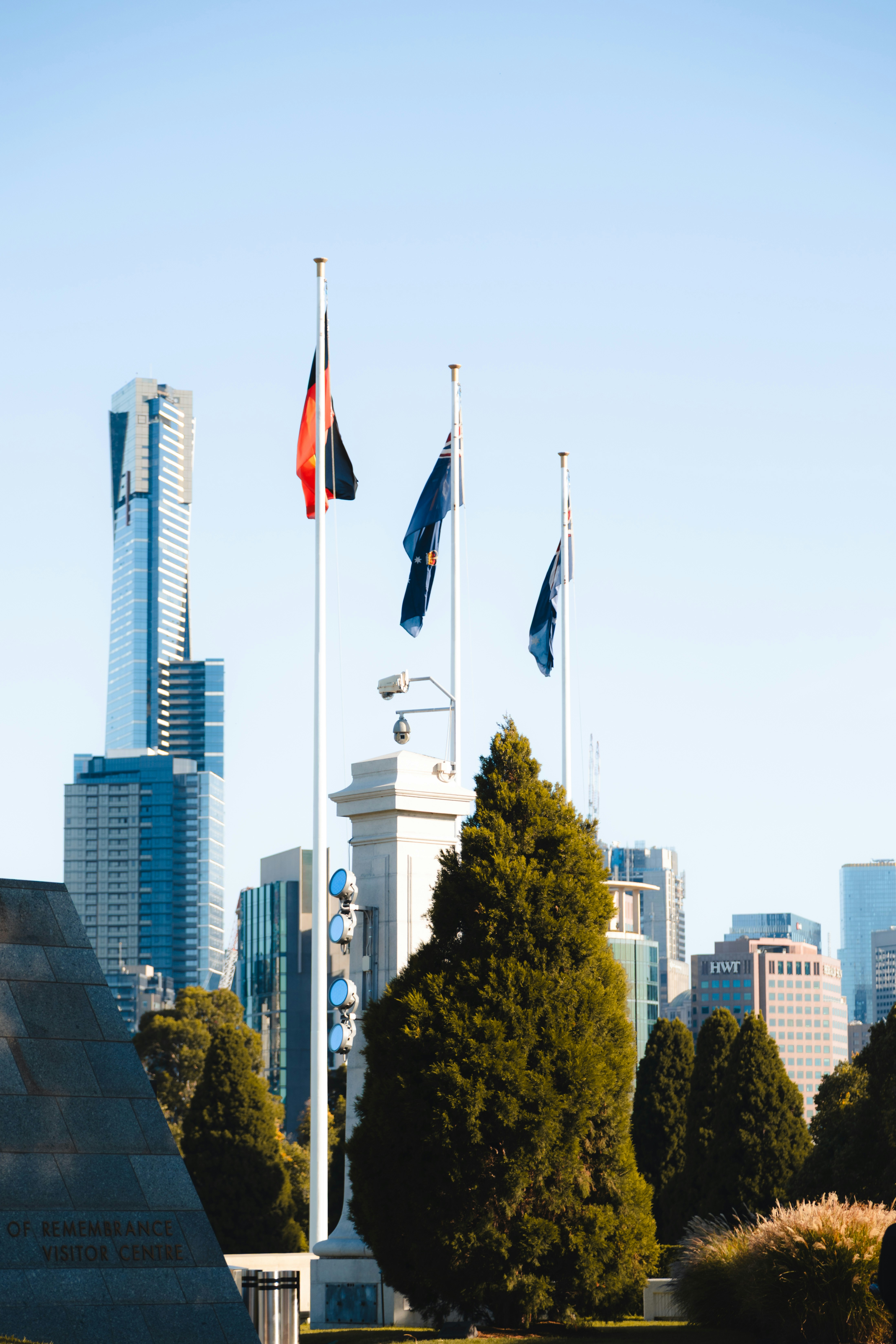 Flagpoles and Cityline: A Quiet Plaza Under Clear Skies