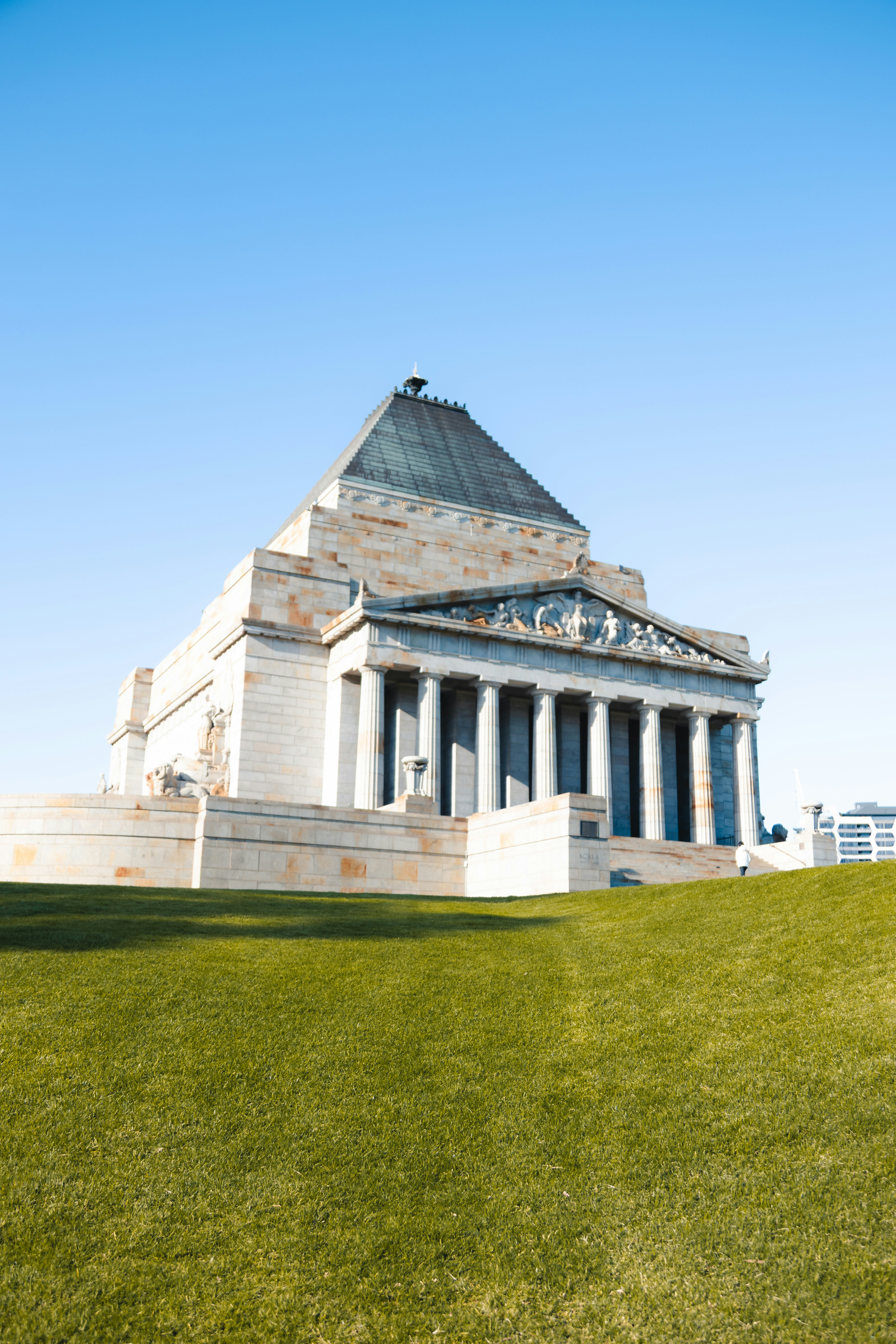 Temple of Terpsichore: A granite monument rising from a sunlit lawn