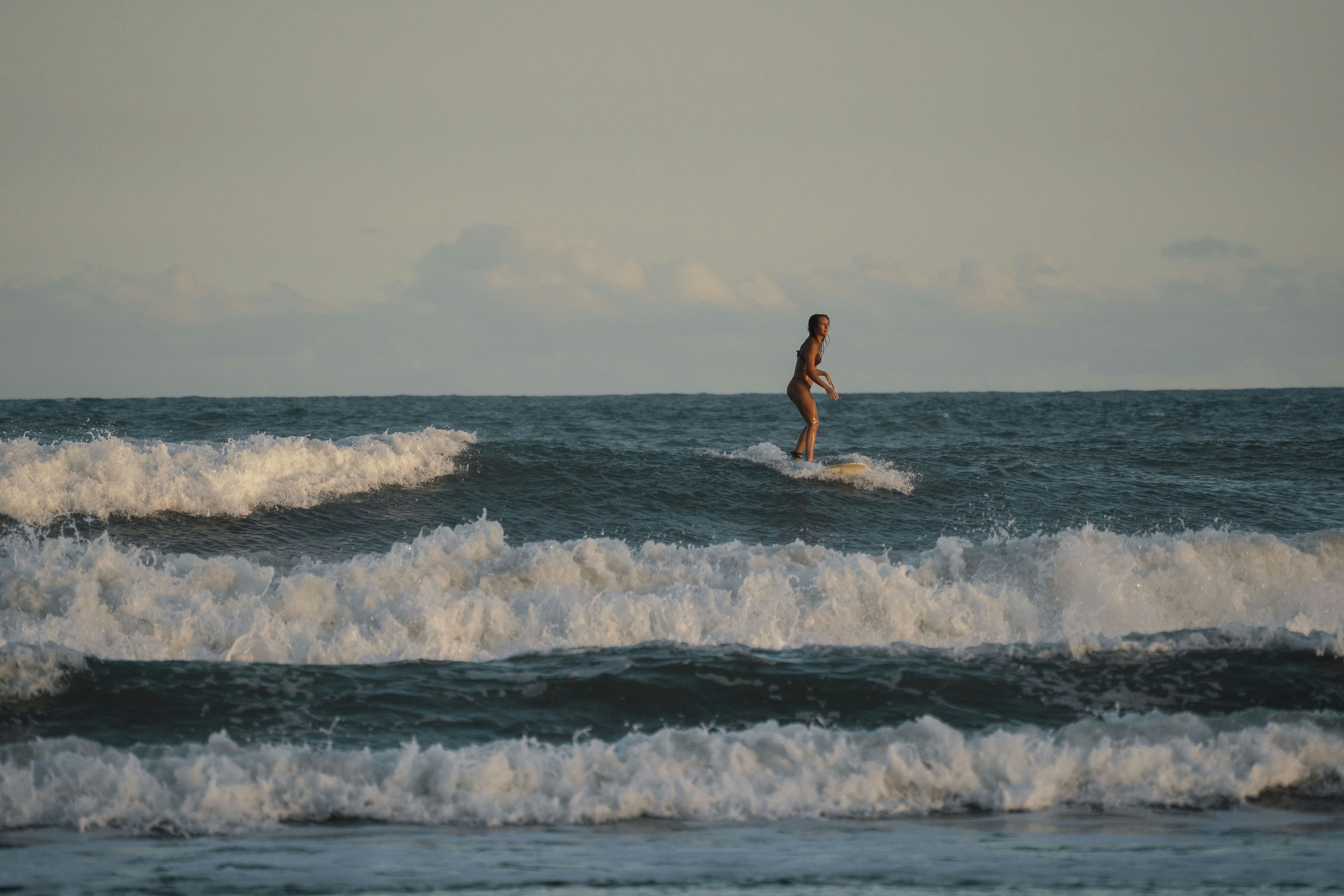 Rider on a Quiet Crest: A lone surfer gliding above rolling Atlantic breakers