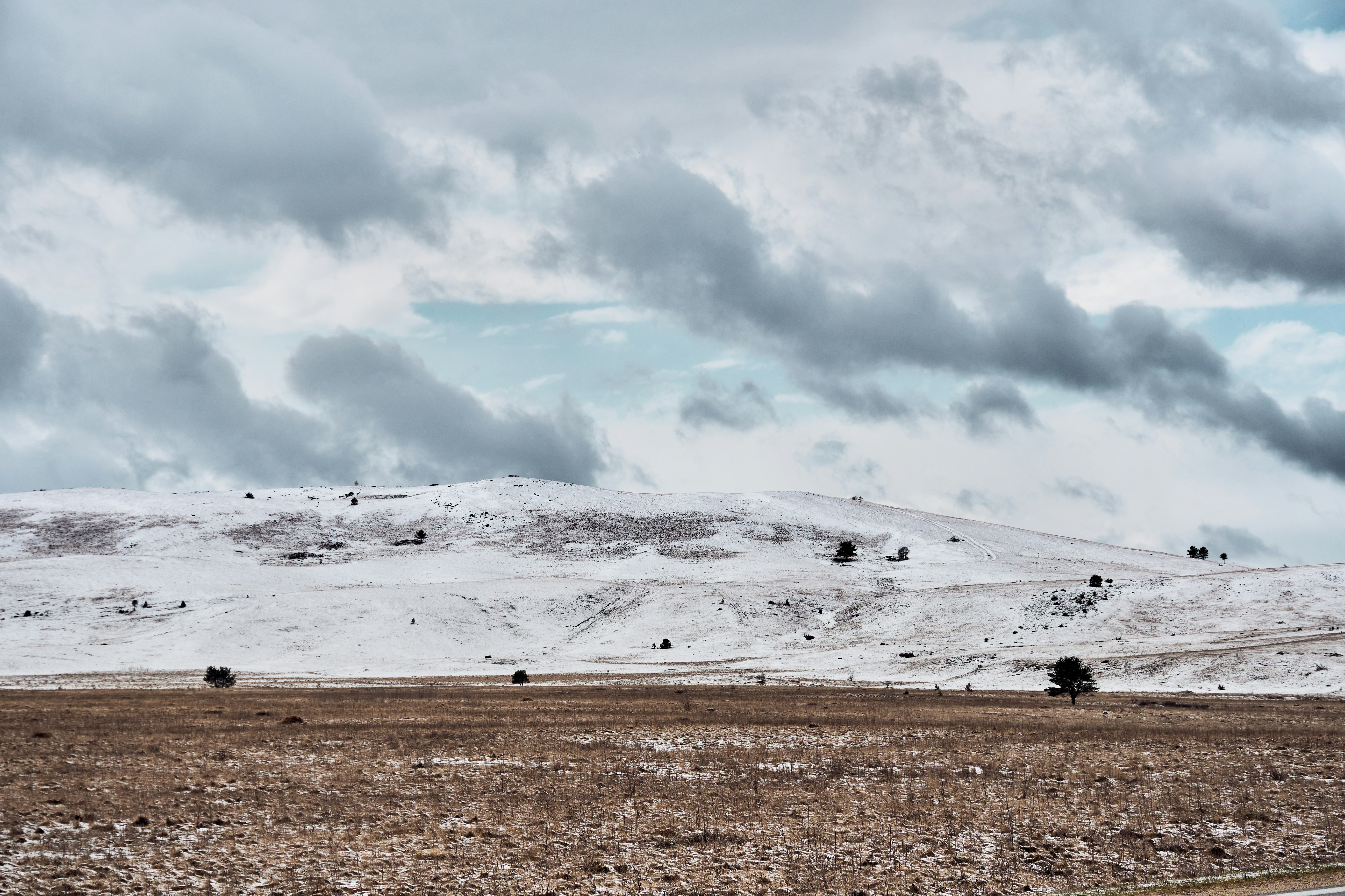 Snow-dusted Hillscape Under a Cloudy Expanse