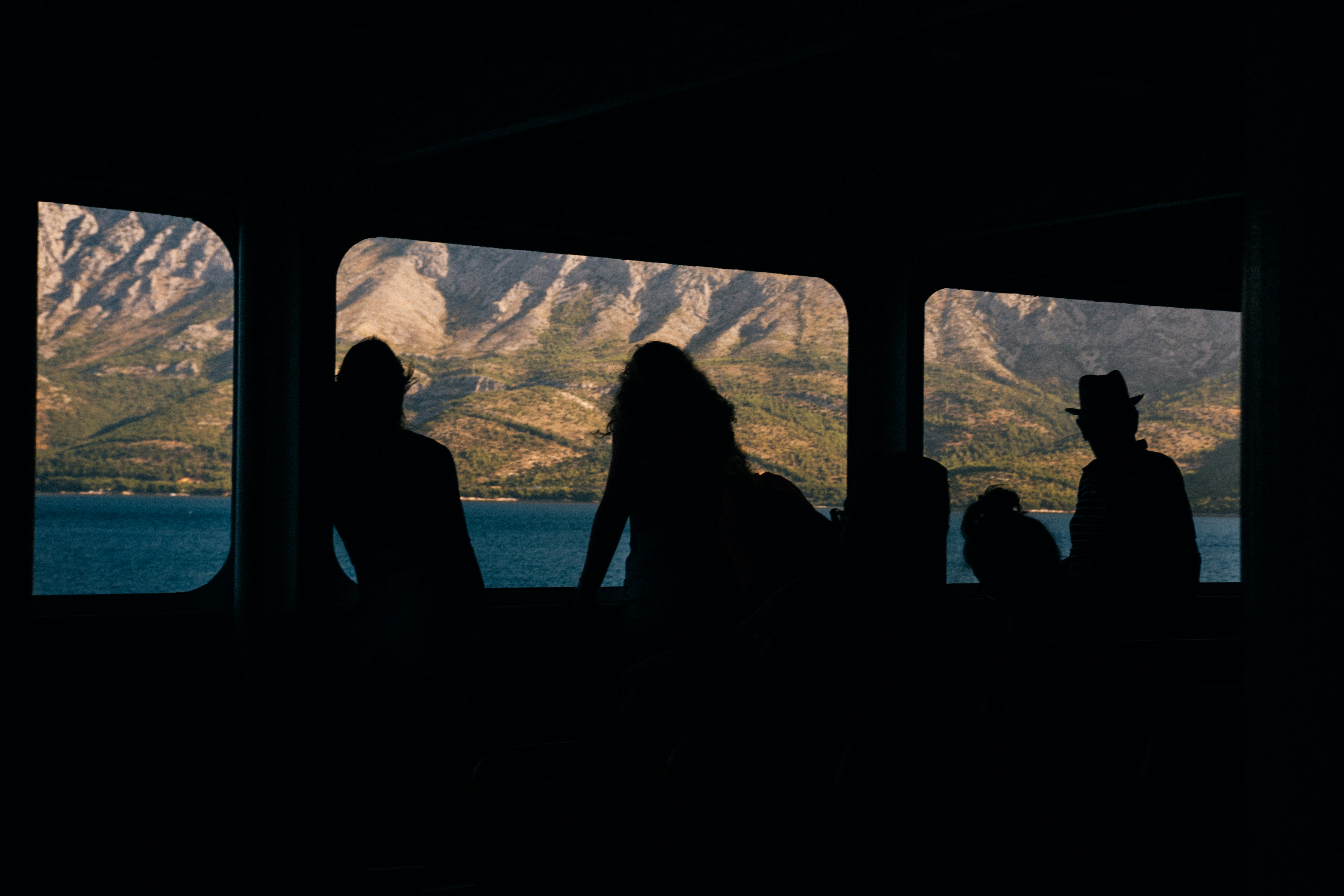 Silhouetted Passengers Overlooking Coastal Mountains