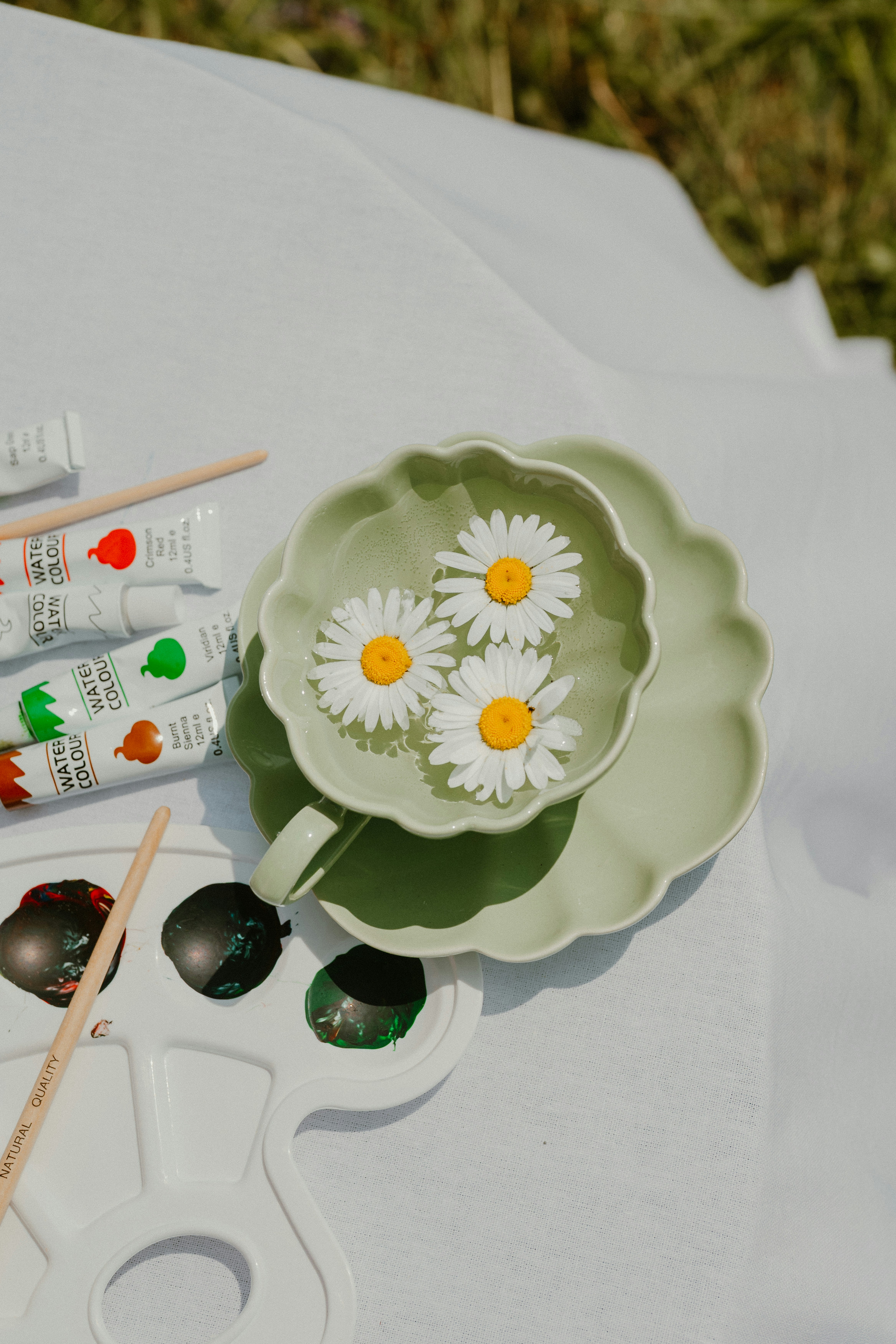 Daisy duet over a calm teacup: an artful still life on white linen