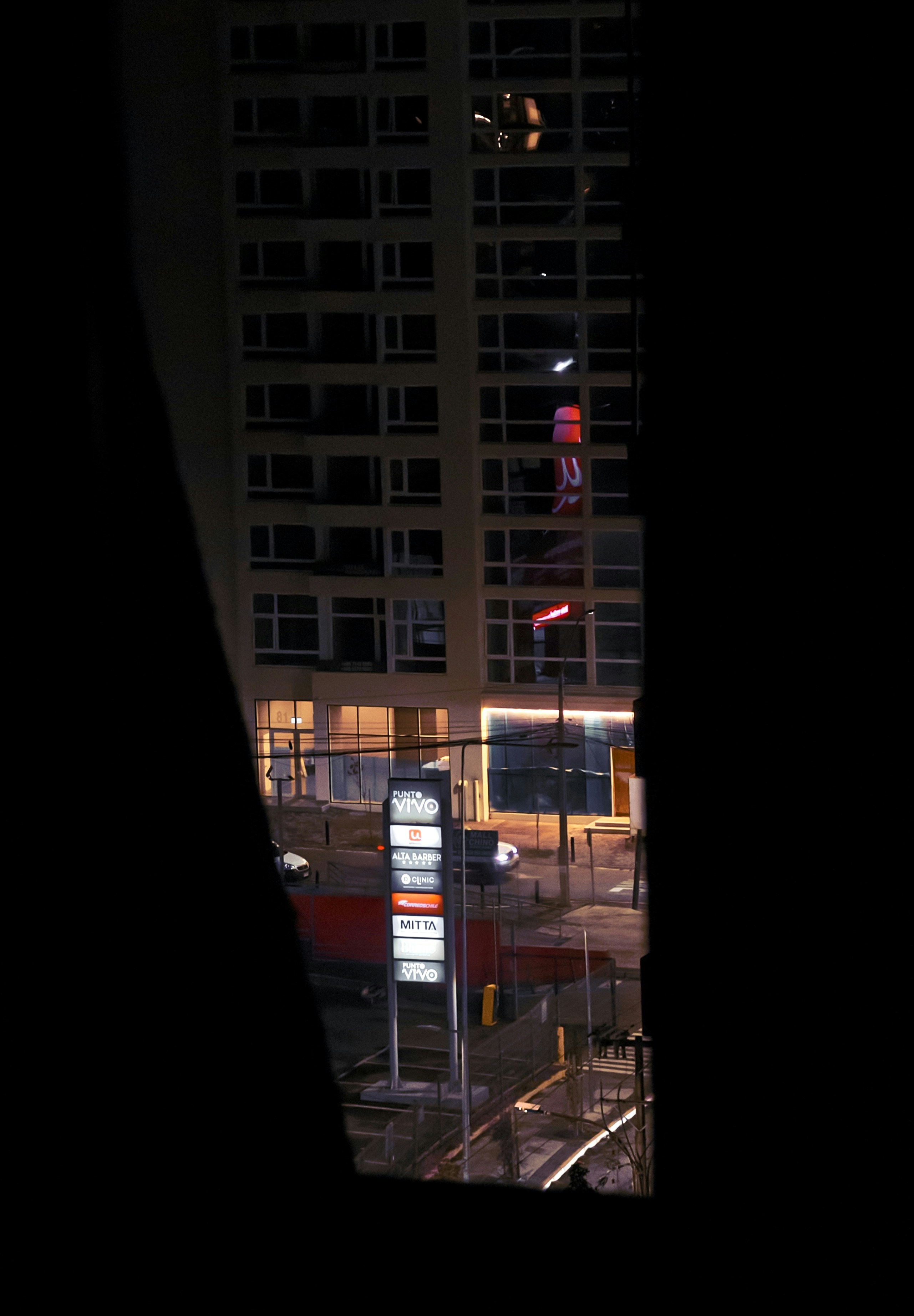 City Neon Through a Balcony Slit