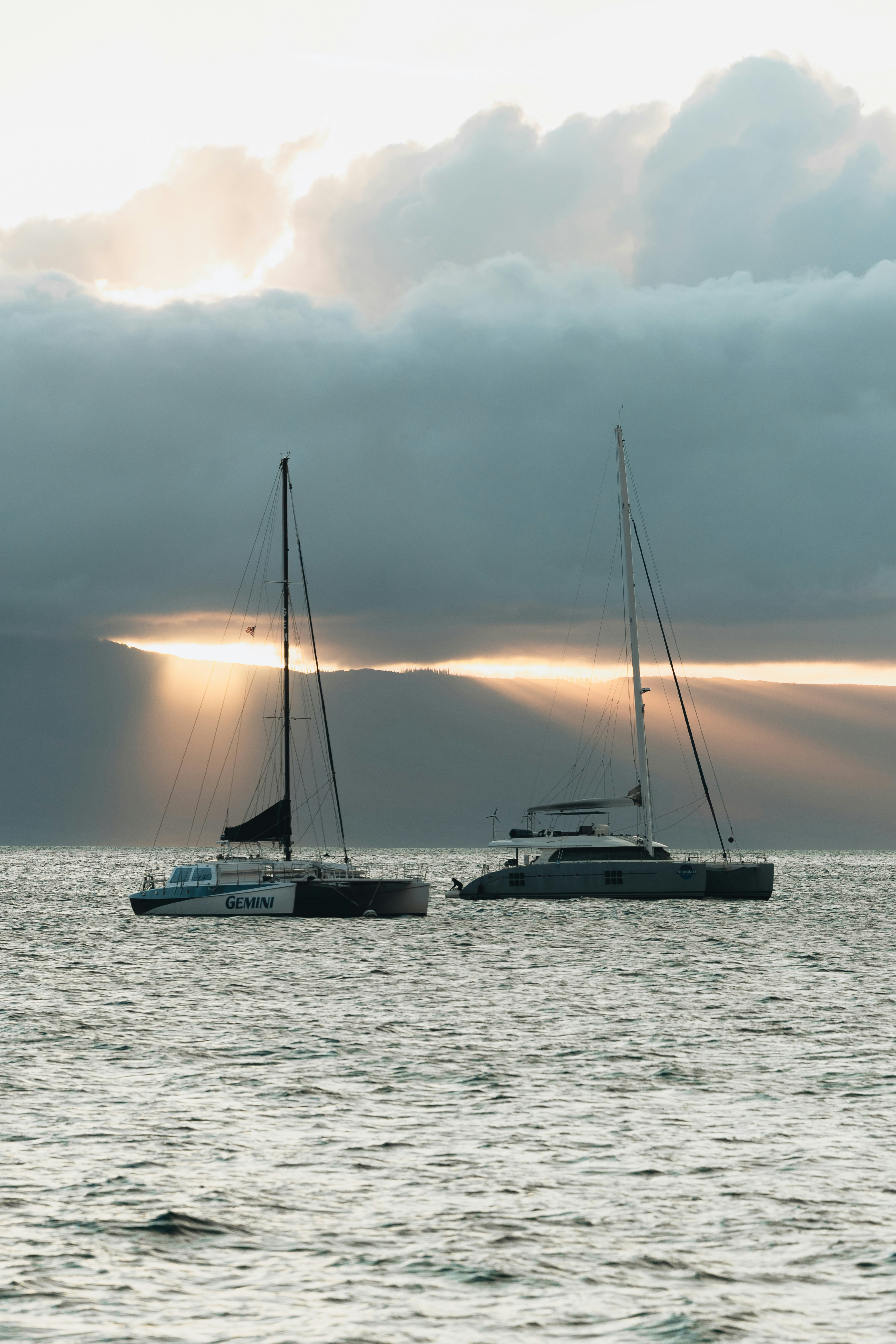 Twin Sailboats at Sunset: Quiet Horizon Between Stormy Clouds