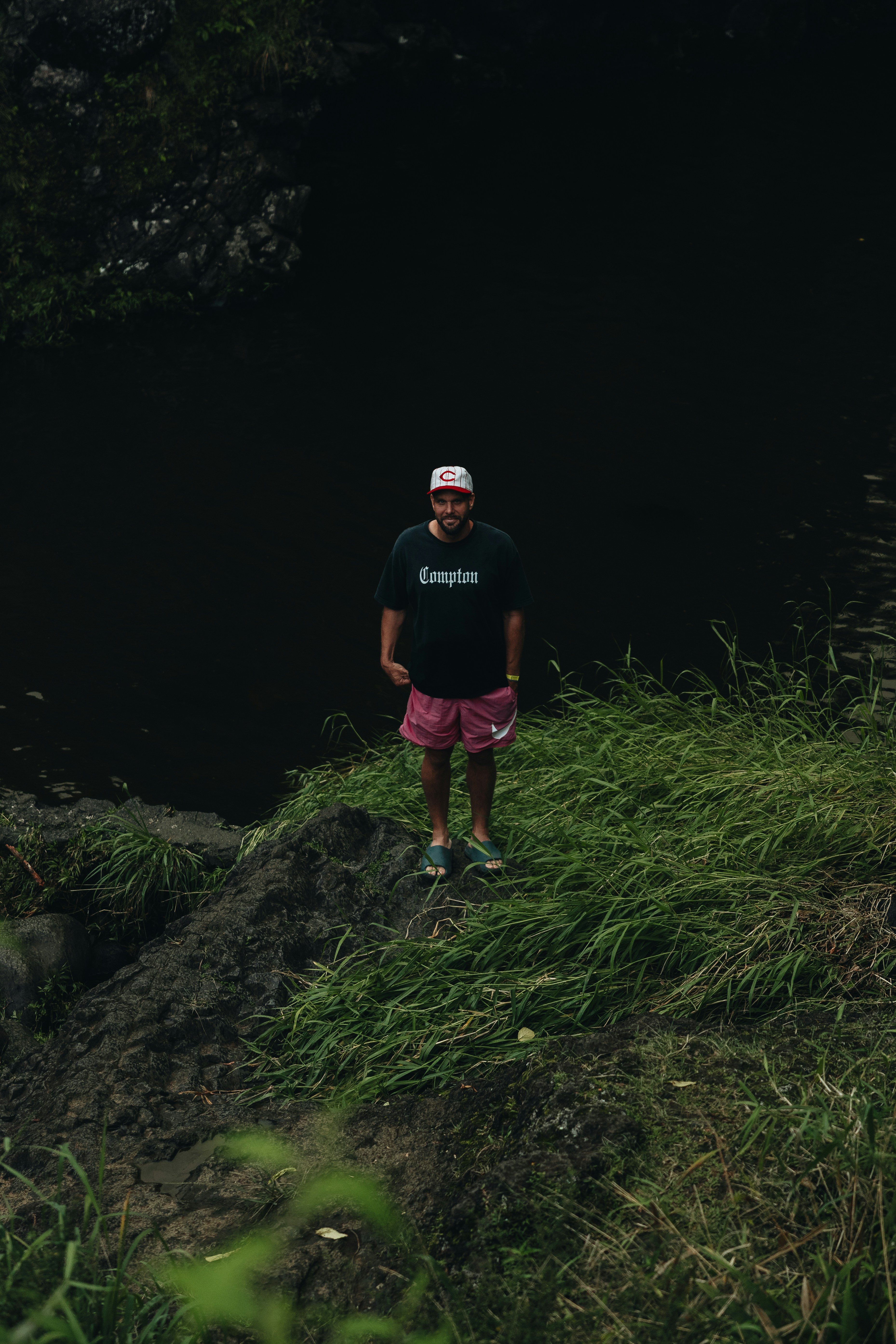 Man in muggy riverside gaze on mossy ledge