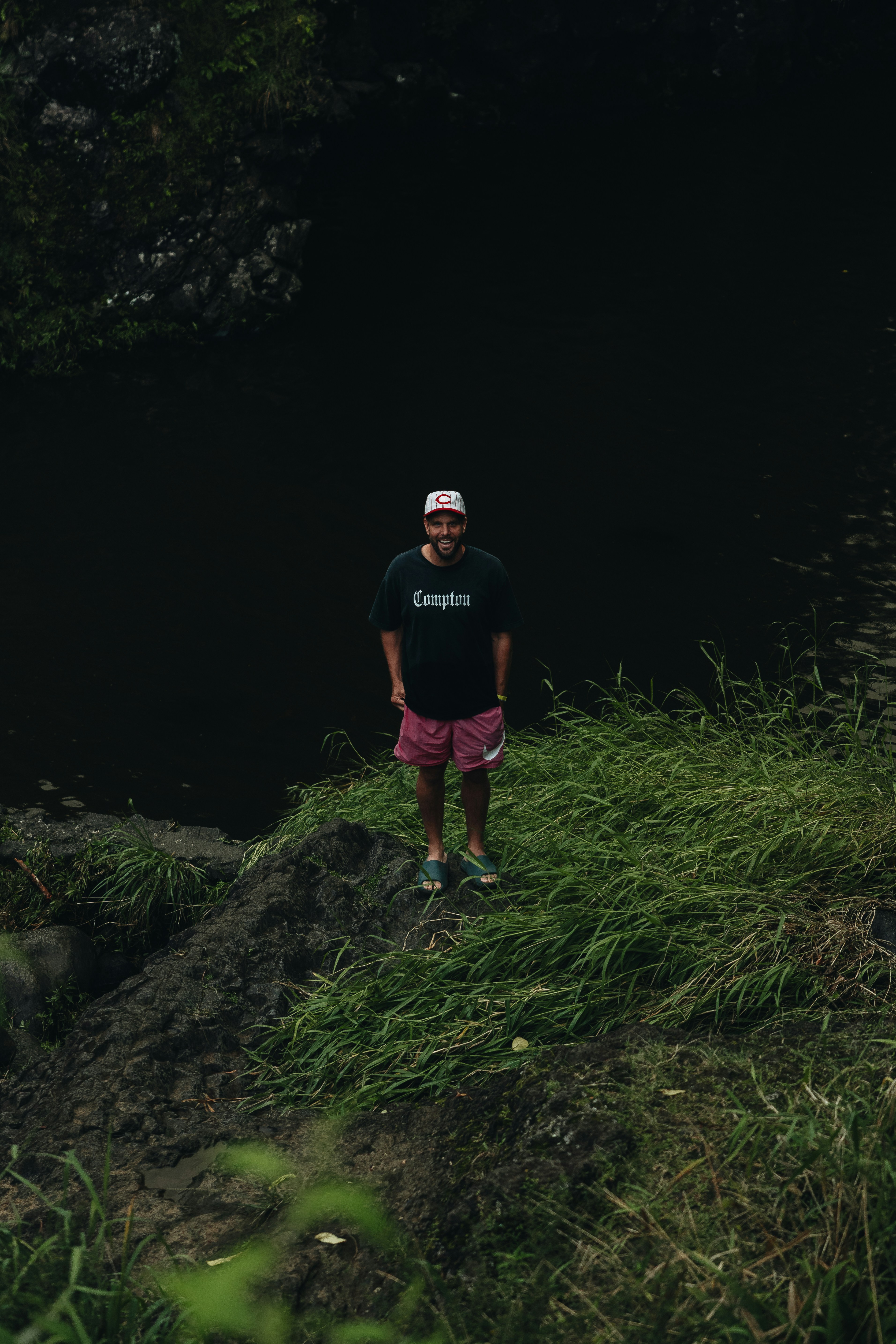 Cliffside Keeper: A Man Stands Tall at the Edge of Shadowed Water