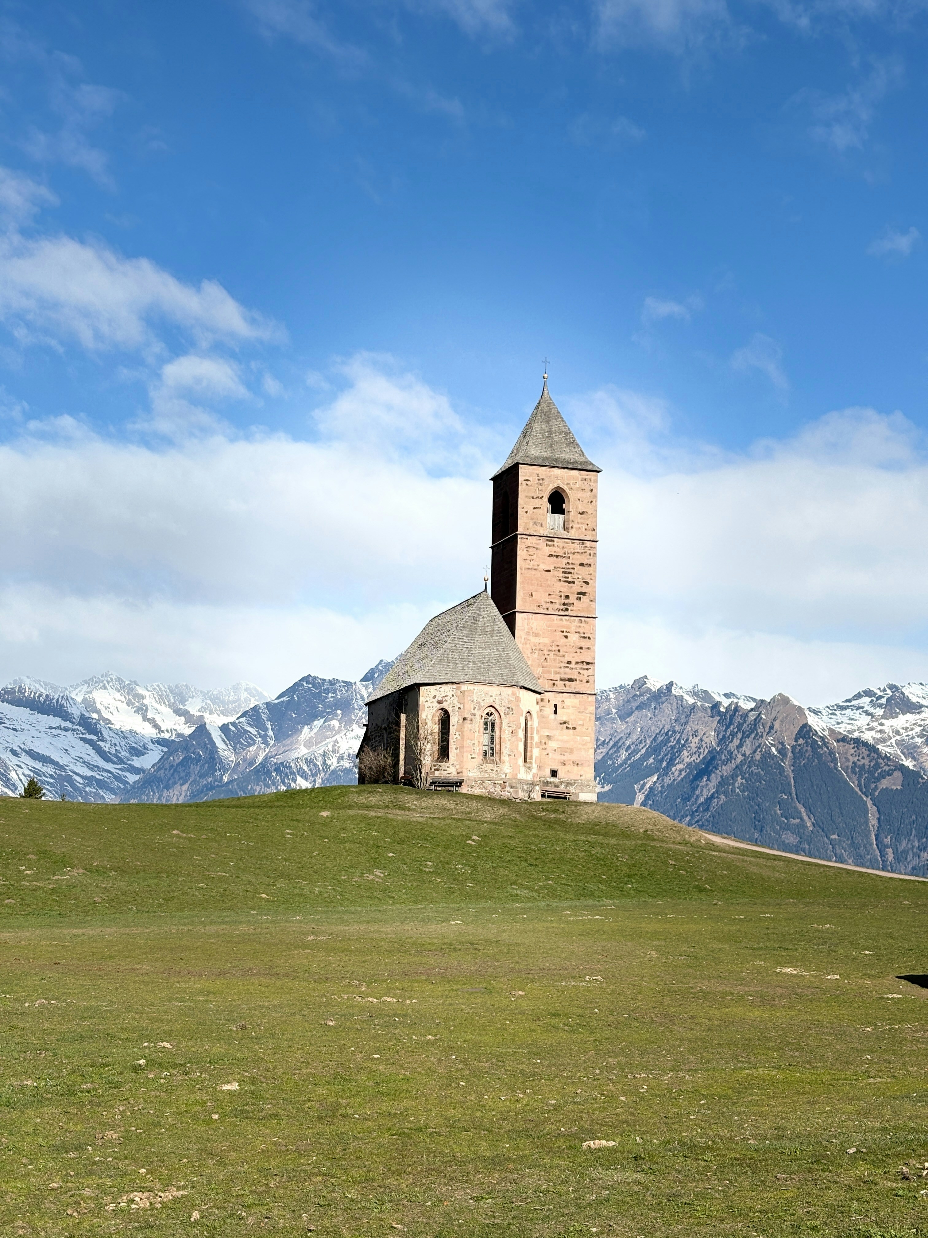 Stone Chapel Upon the Hill under a Clear Alpine Sky
