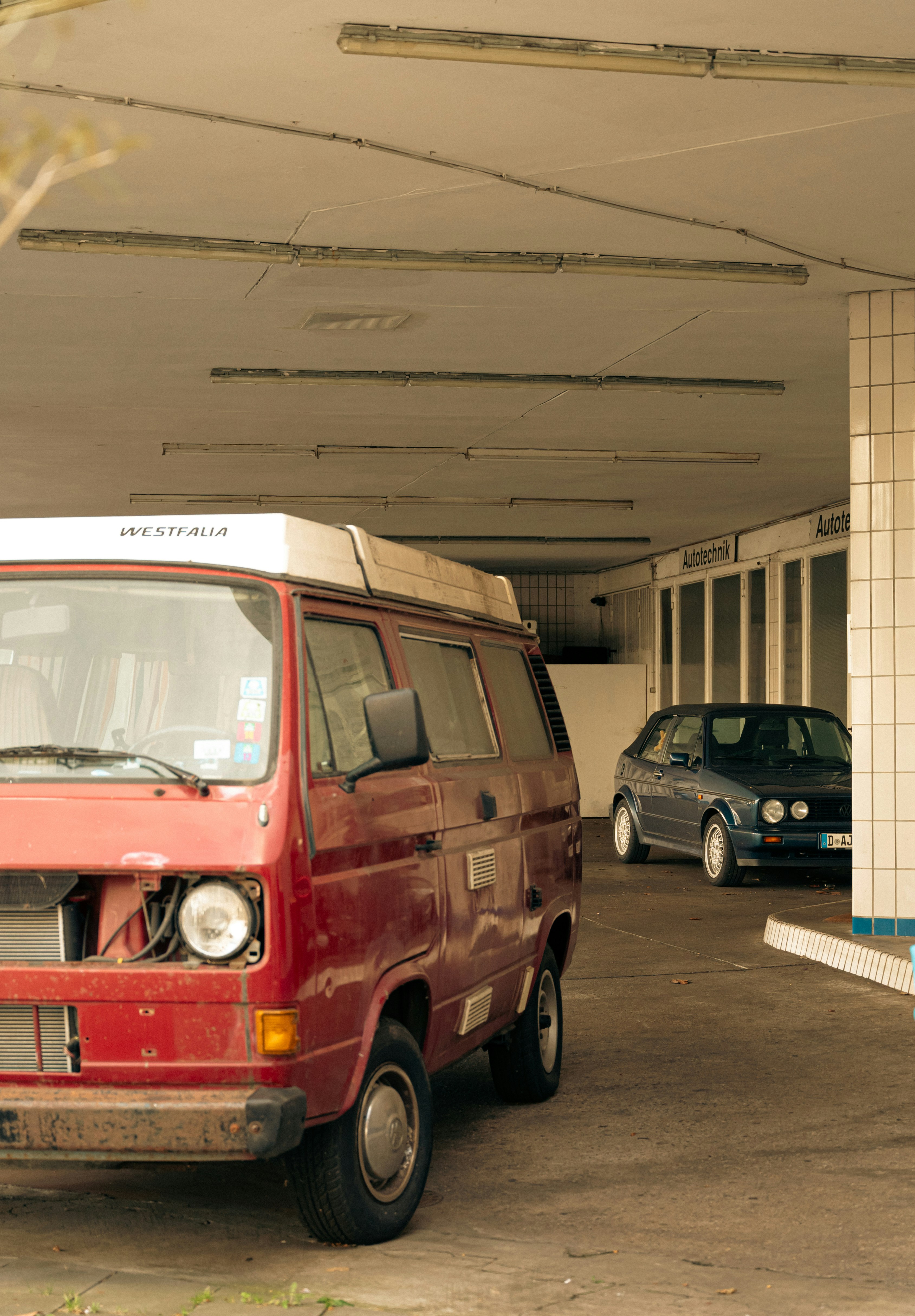 Red van in a shadowed auto shop corridor