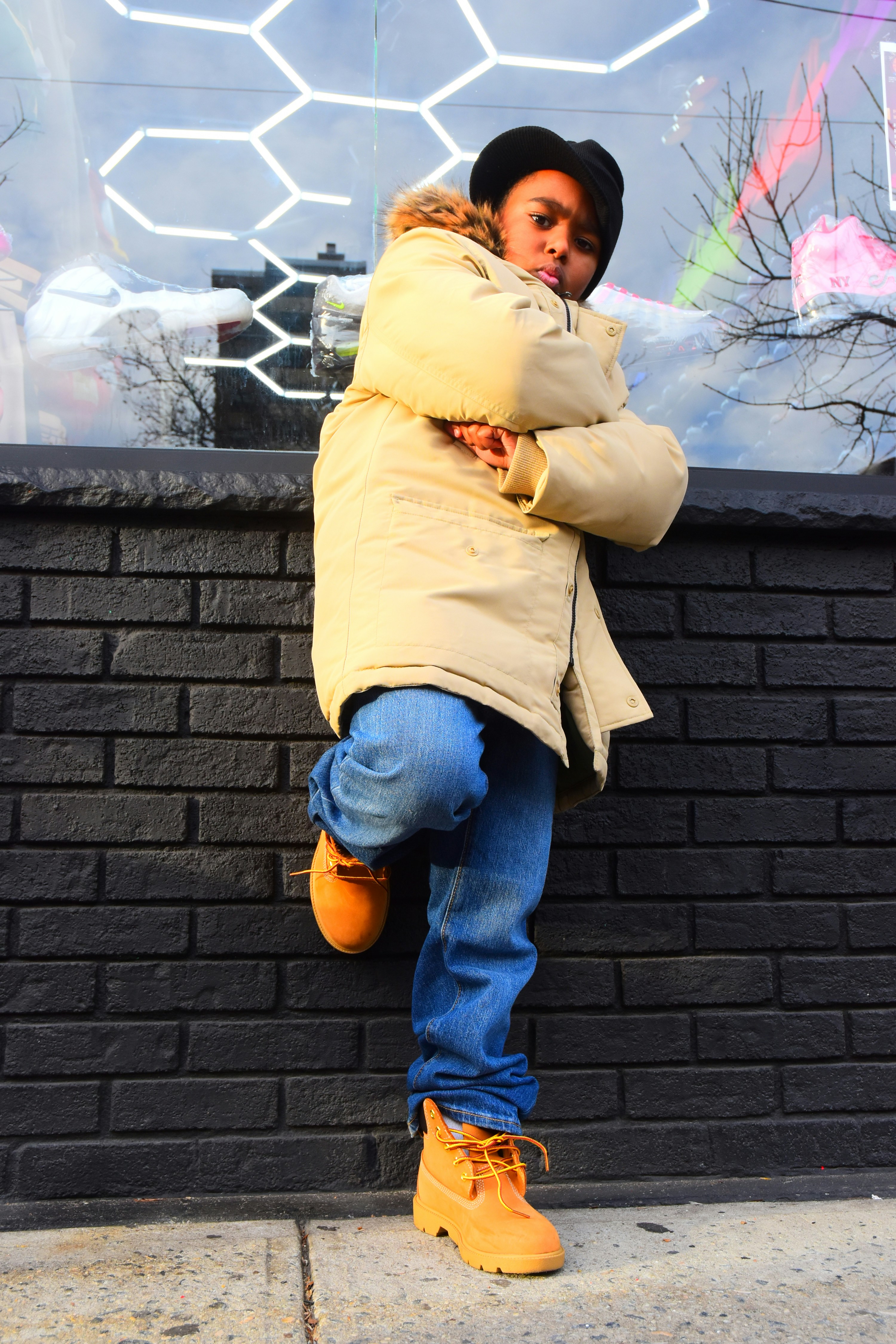 Urban Chill: A Child Lounges Against a Neon-Patterned Window