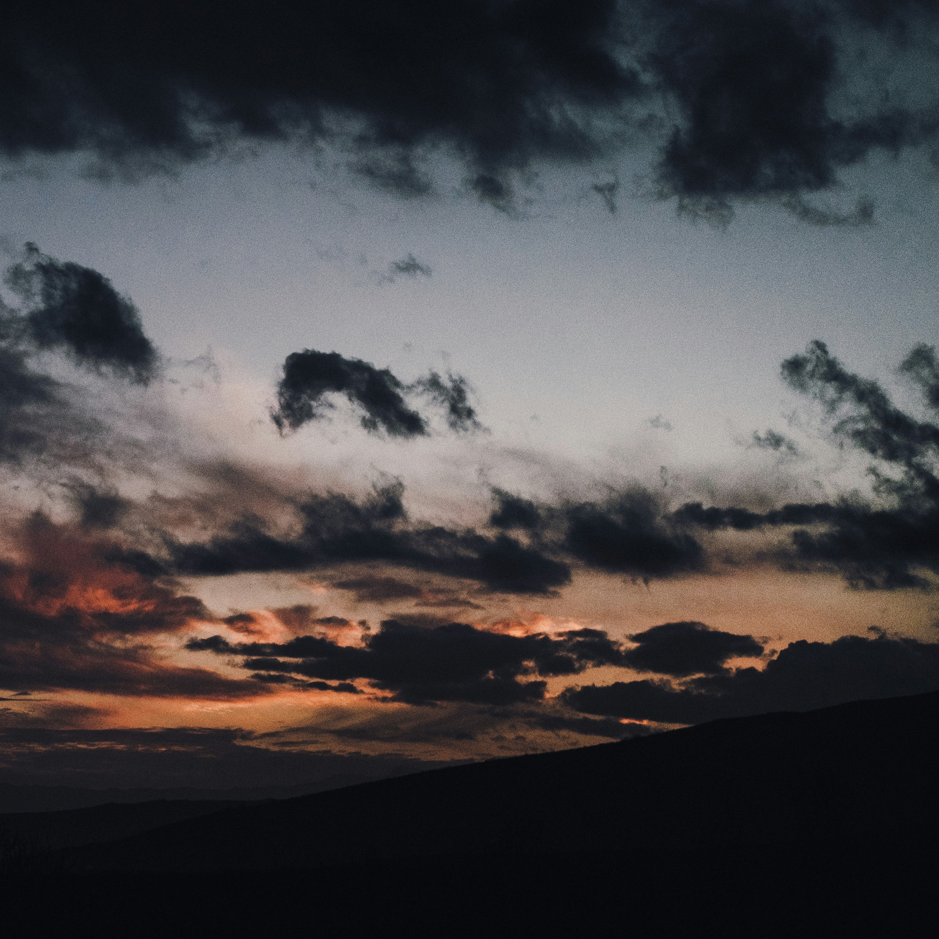 Crimson Horizon: Silhouetted Ridge Under a Velvet Sky