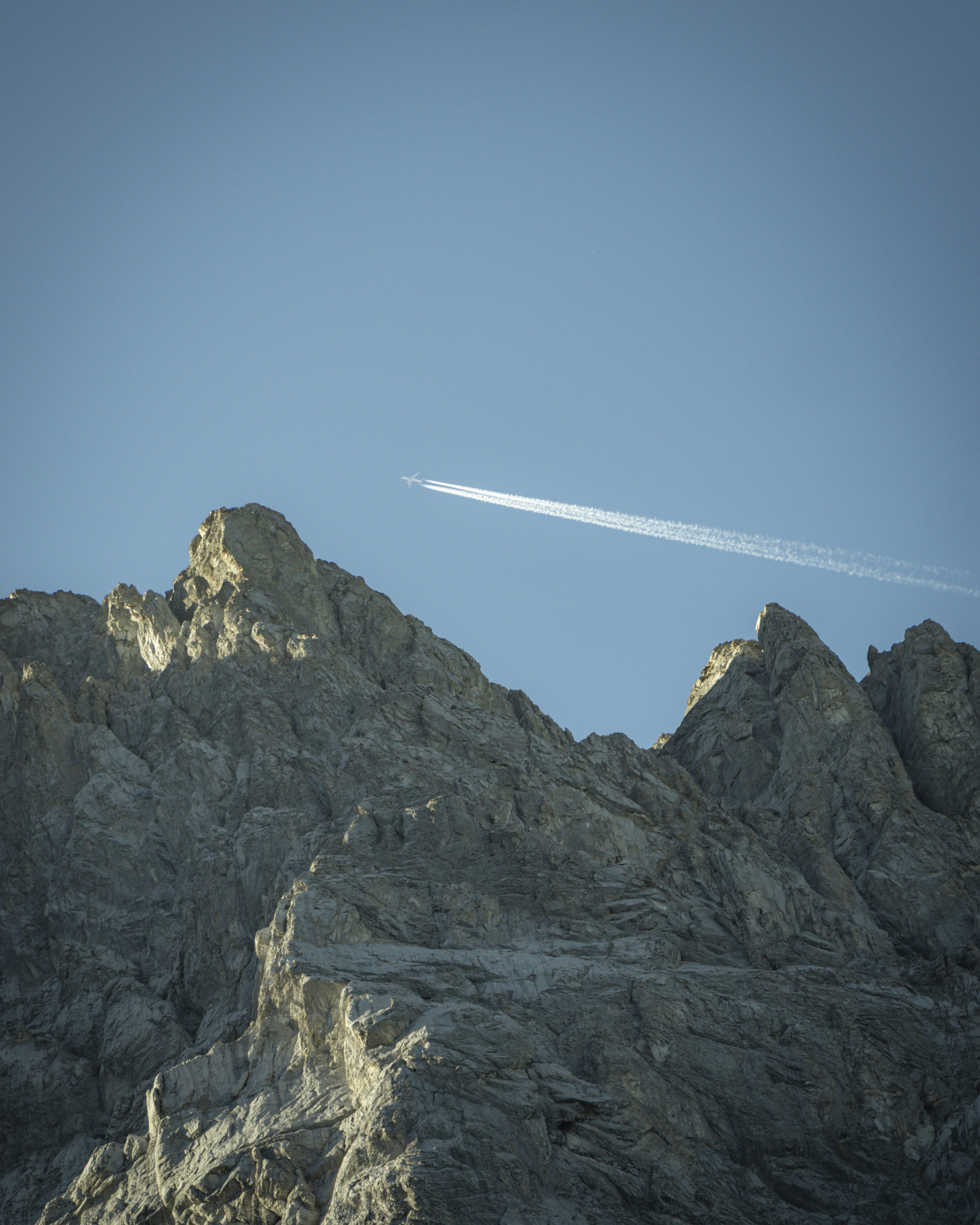 Crystalline Peak Under a Jet-White Trail