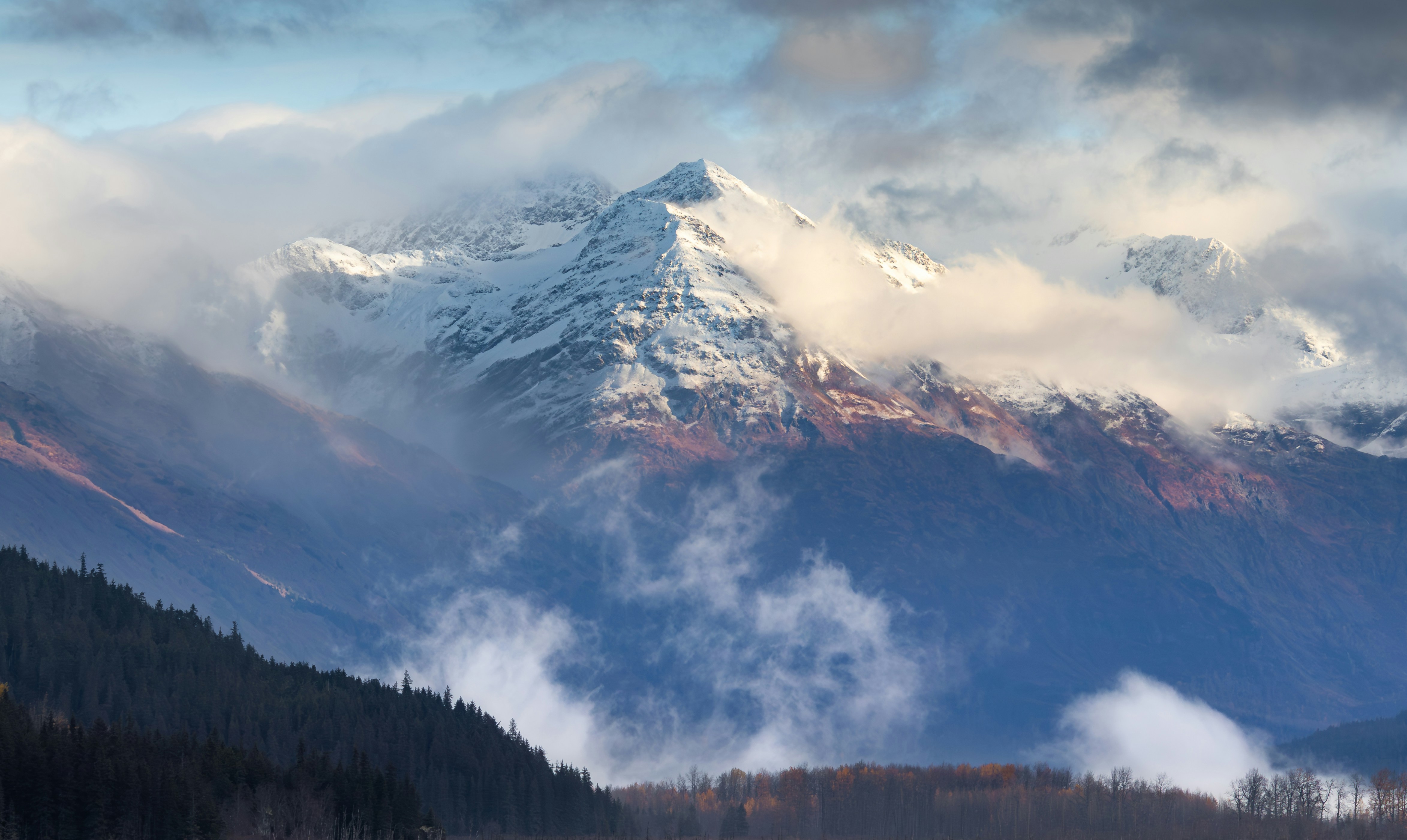 Snow-crowned Peak Piercing a Veil of Clouds