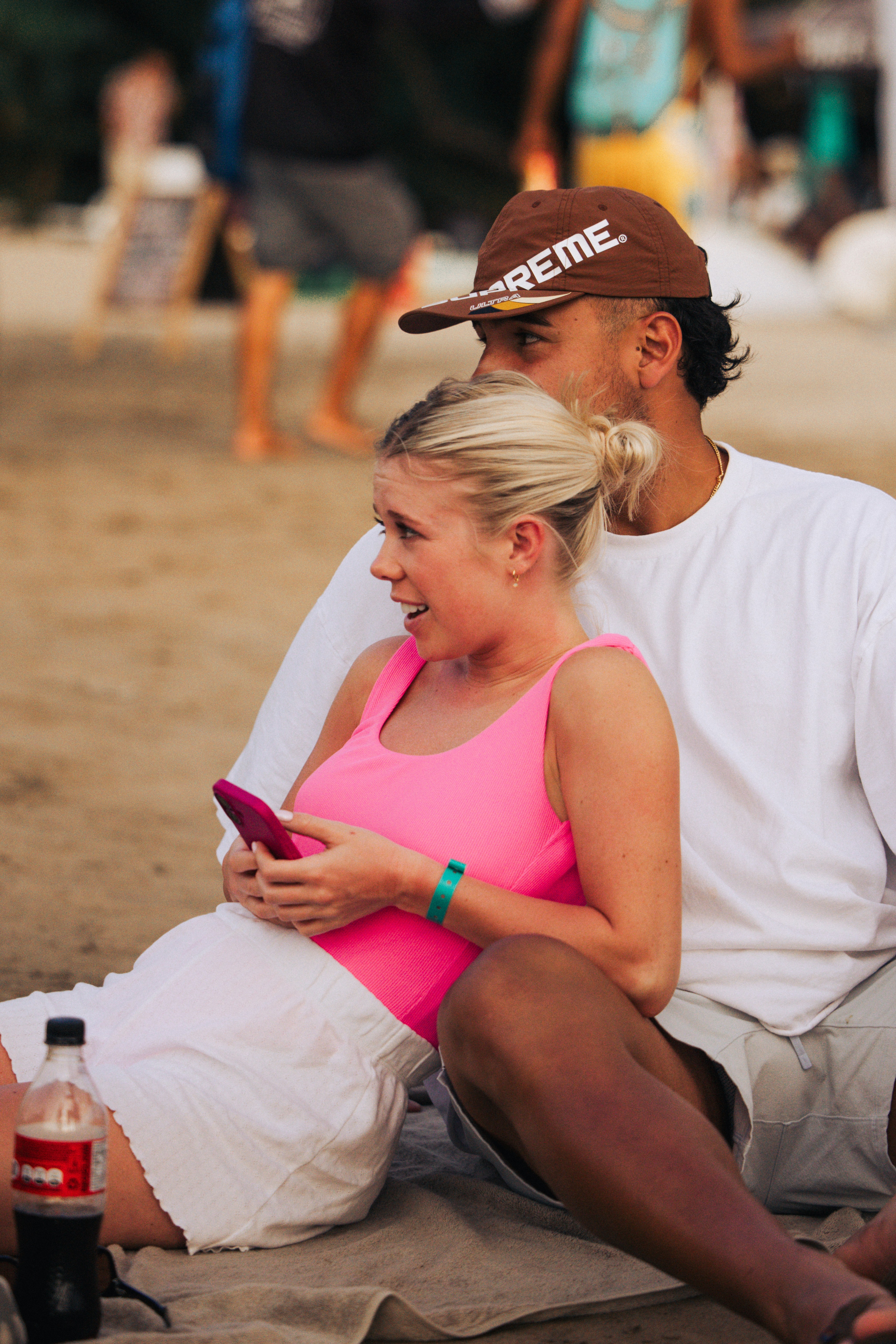 Beachside Couple Shares a Quiet Moment, Pink Tank Top Bright in the Sand