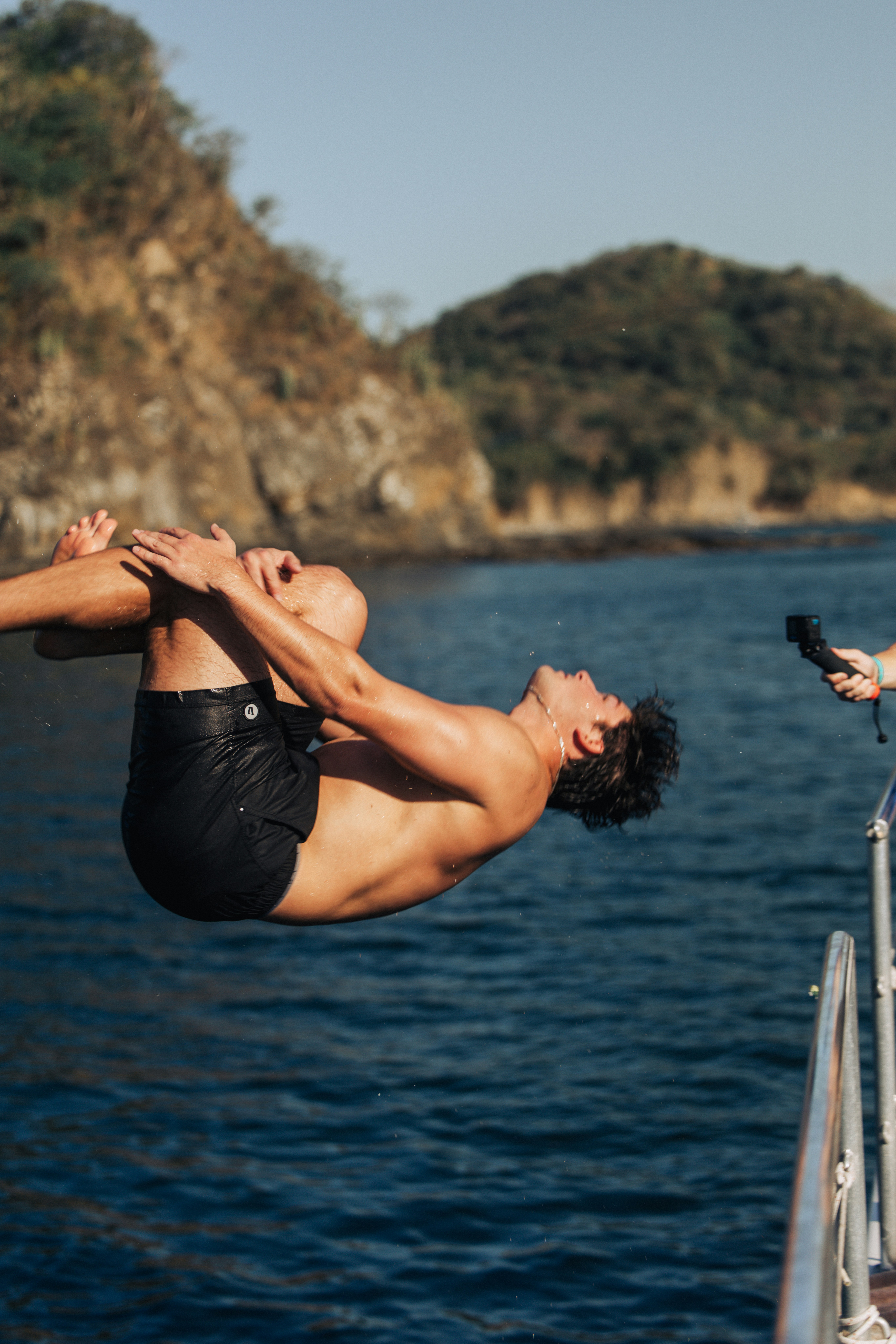 Inverted splash: a athletic dive off a sunlit boat