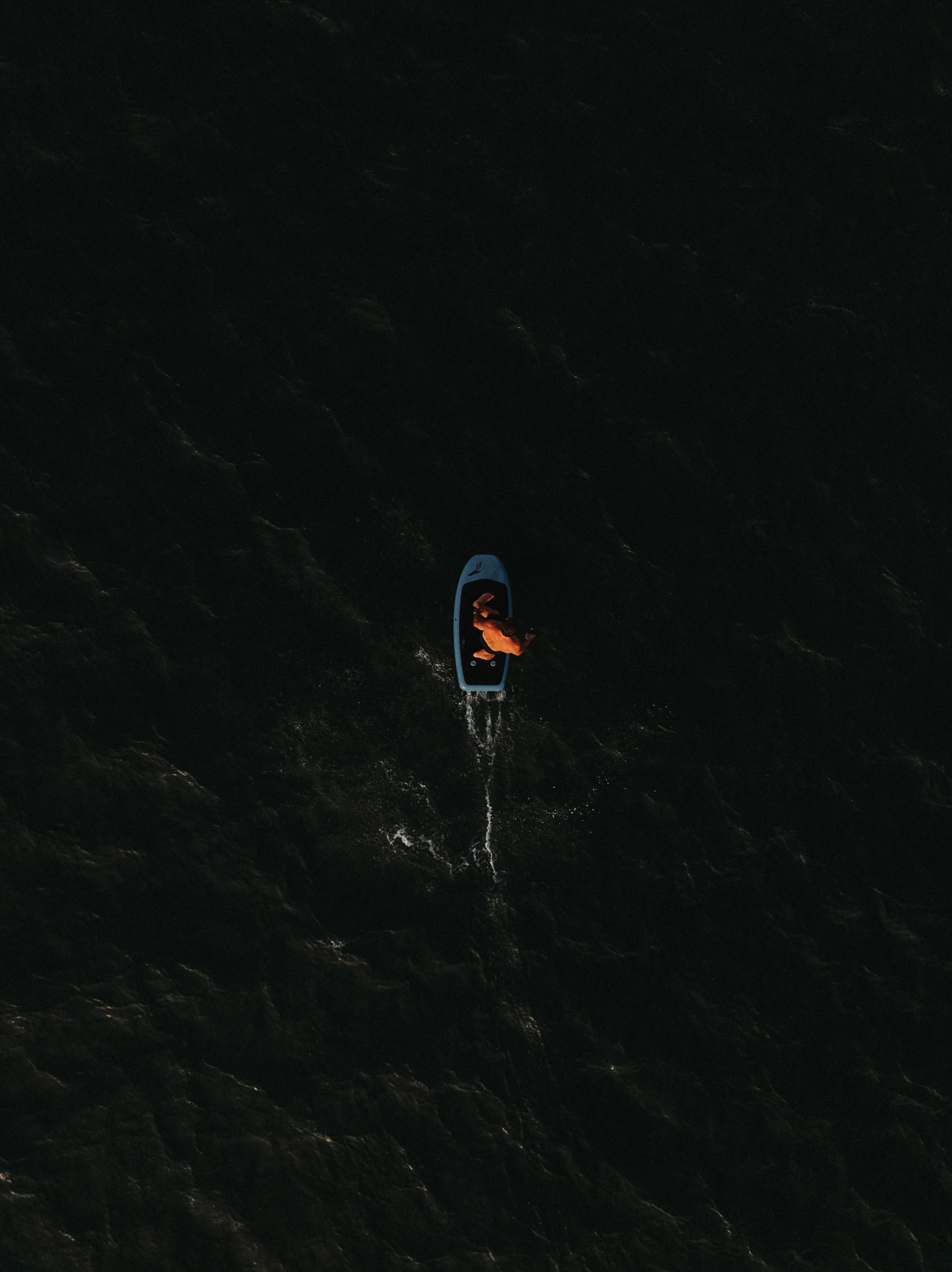 Single Passenger, Quiet Wake: A Distant Paddle in Dark Waters