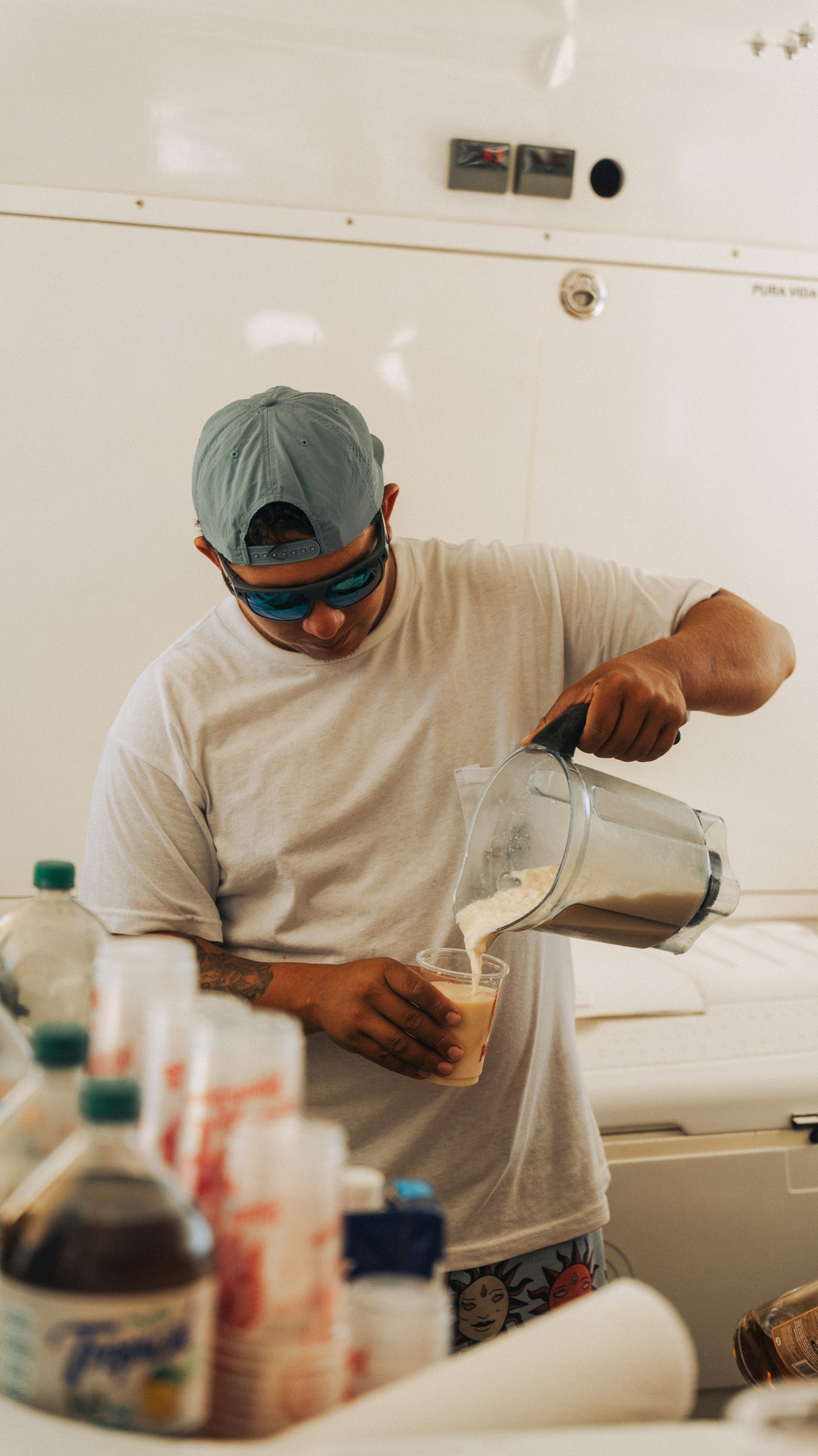 Blue-tinted focus: pouring a drink in a casual kitchen scene