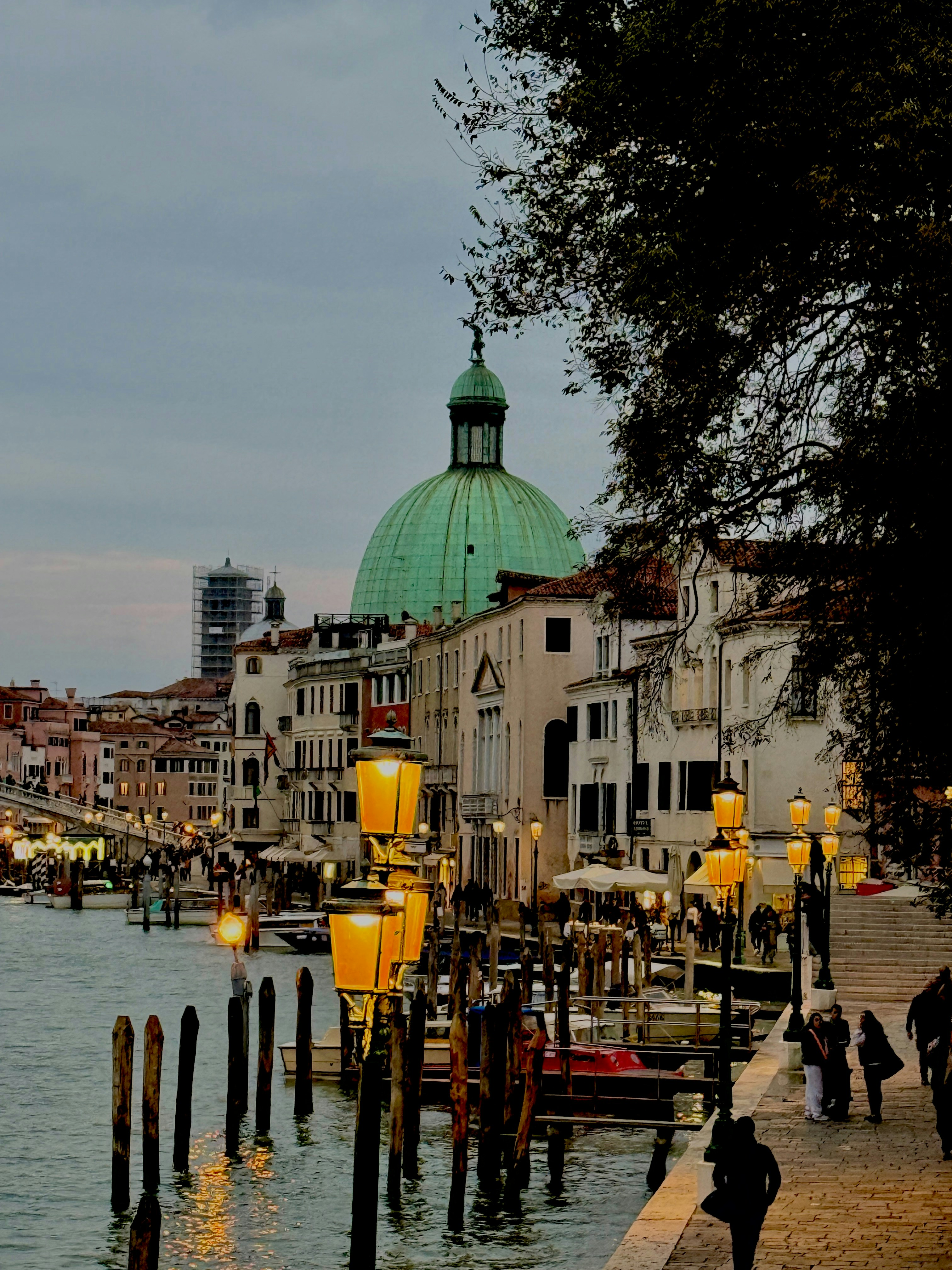 Gondola streetlights and the green dome of Venice at dusk