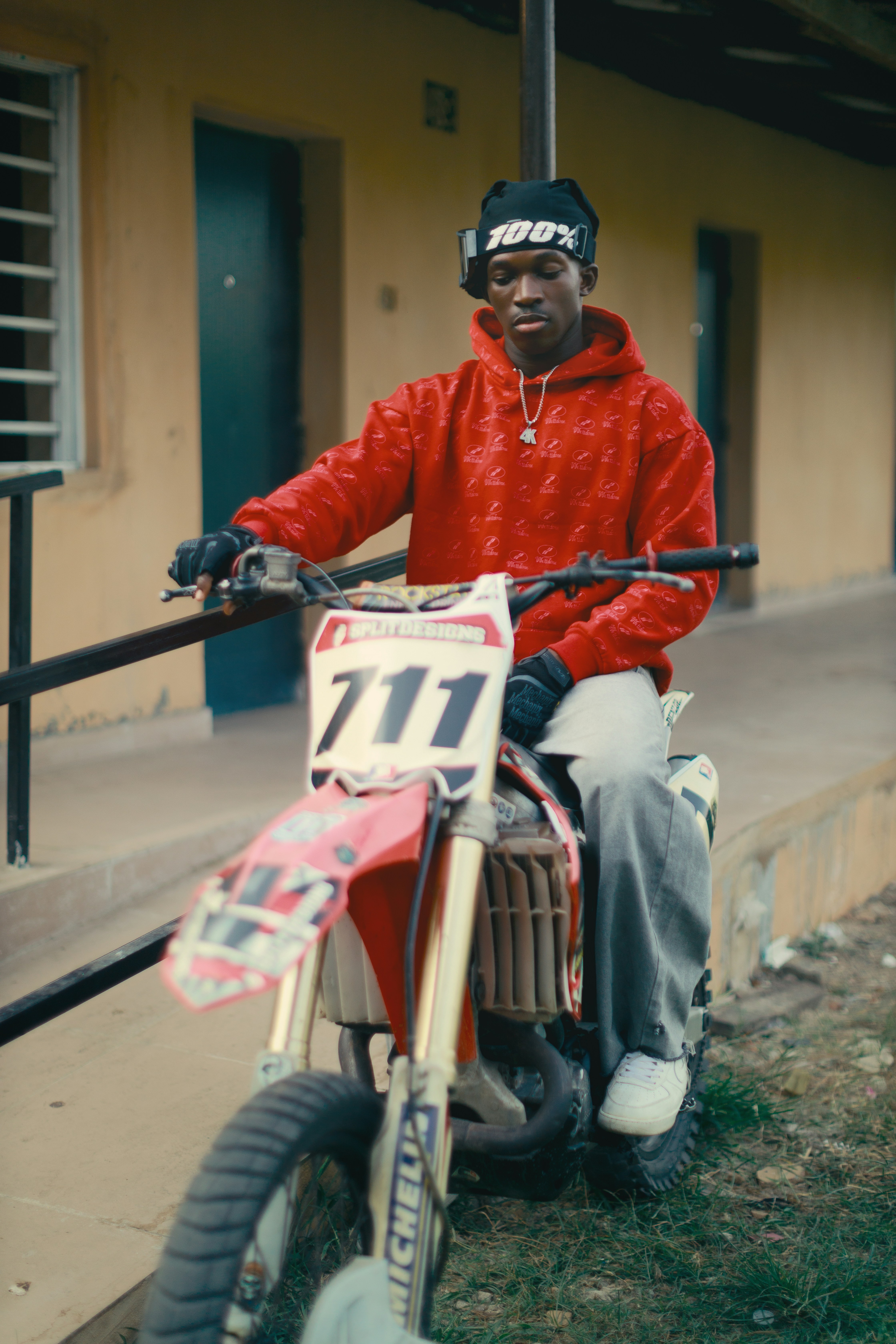 Red Hoodie Rider: Centered Confidence on a Dirt-Toned Street