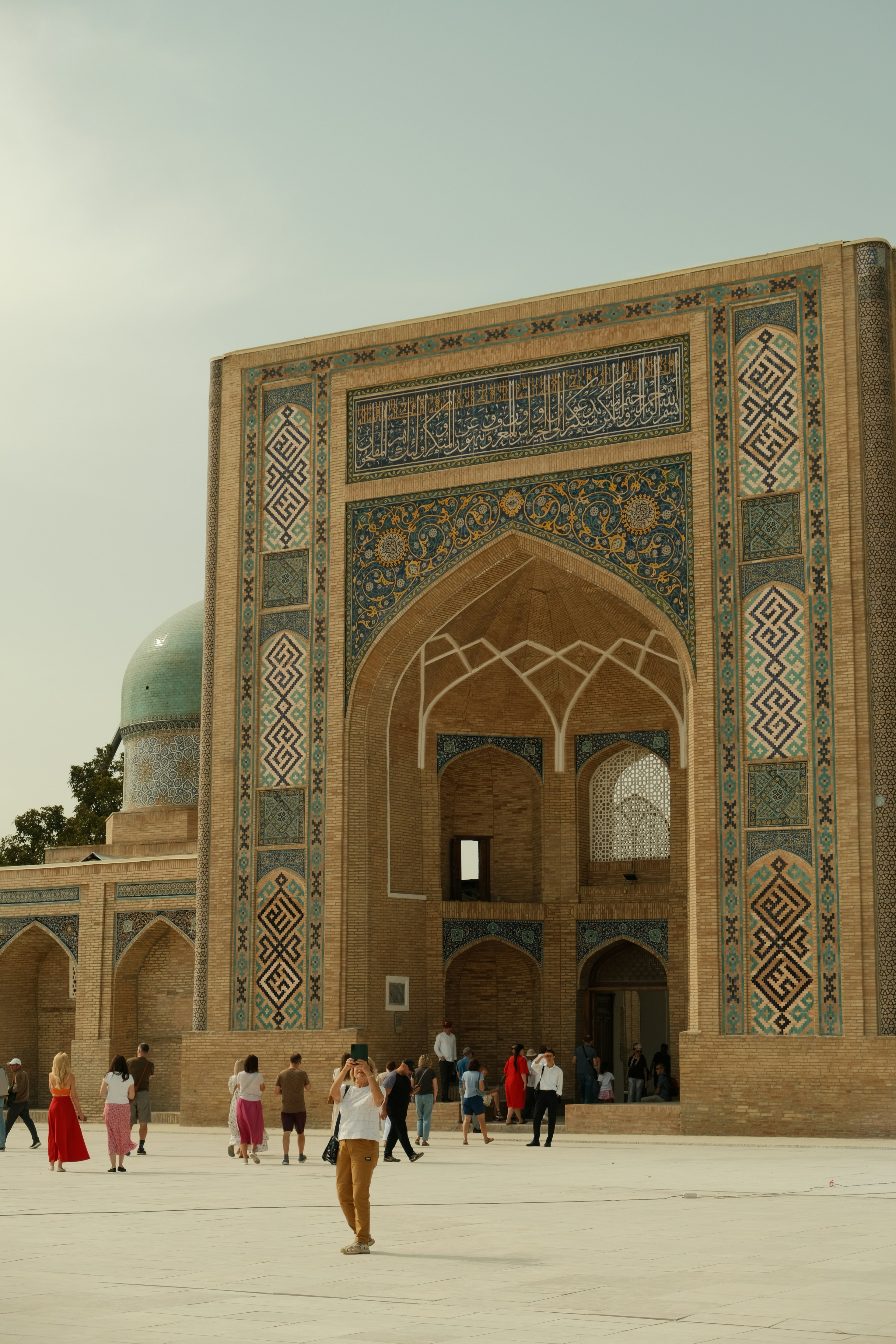 Gate of Intricate Blueworks: A Sunlit Portal and Courtyard Gather