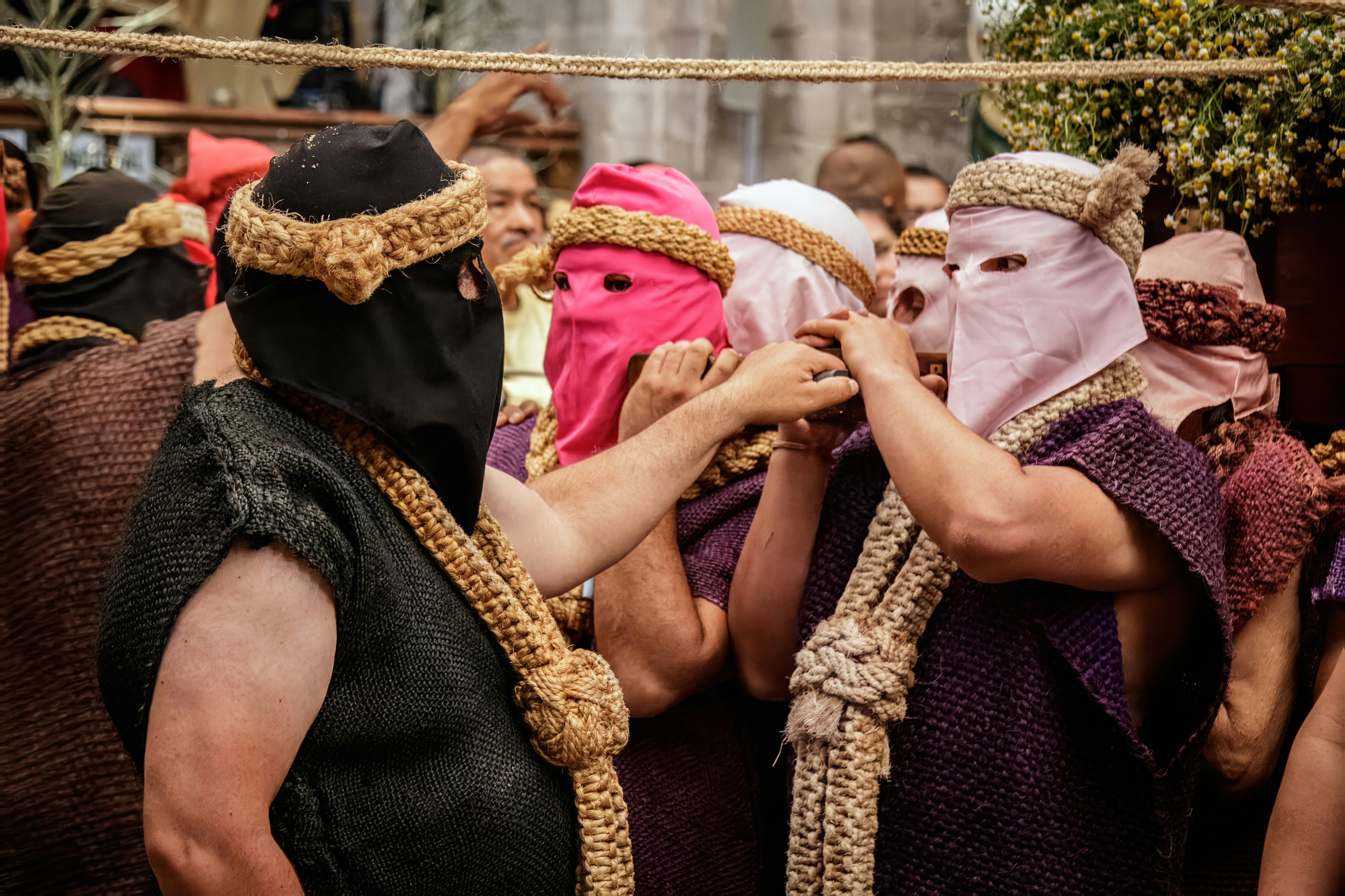 Ritual Veil: Hands clasped in a festive moment among masked participants