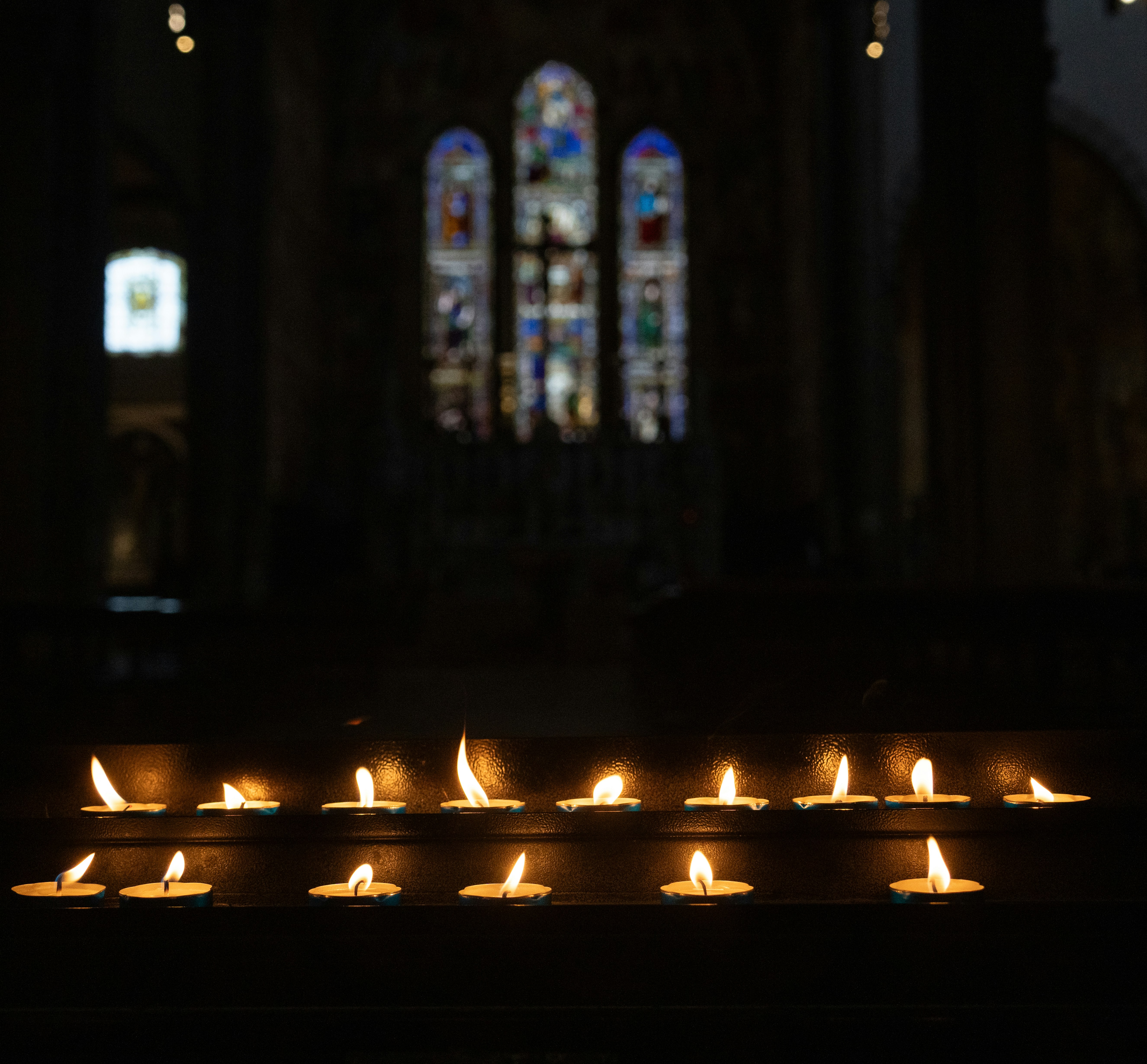 Candles in a Dim Church Illuminate a Quiet Sanctuary