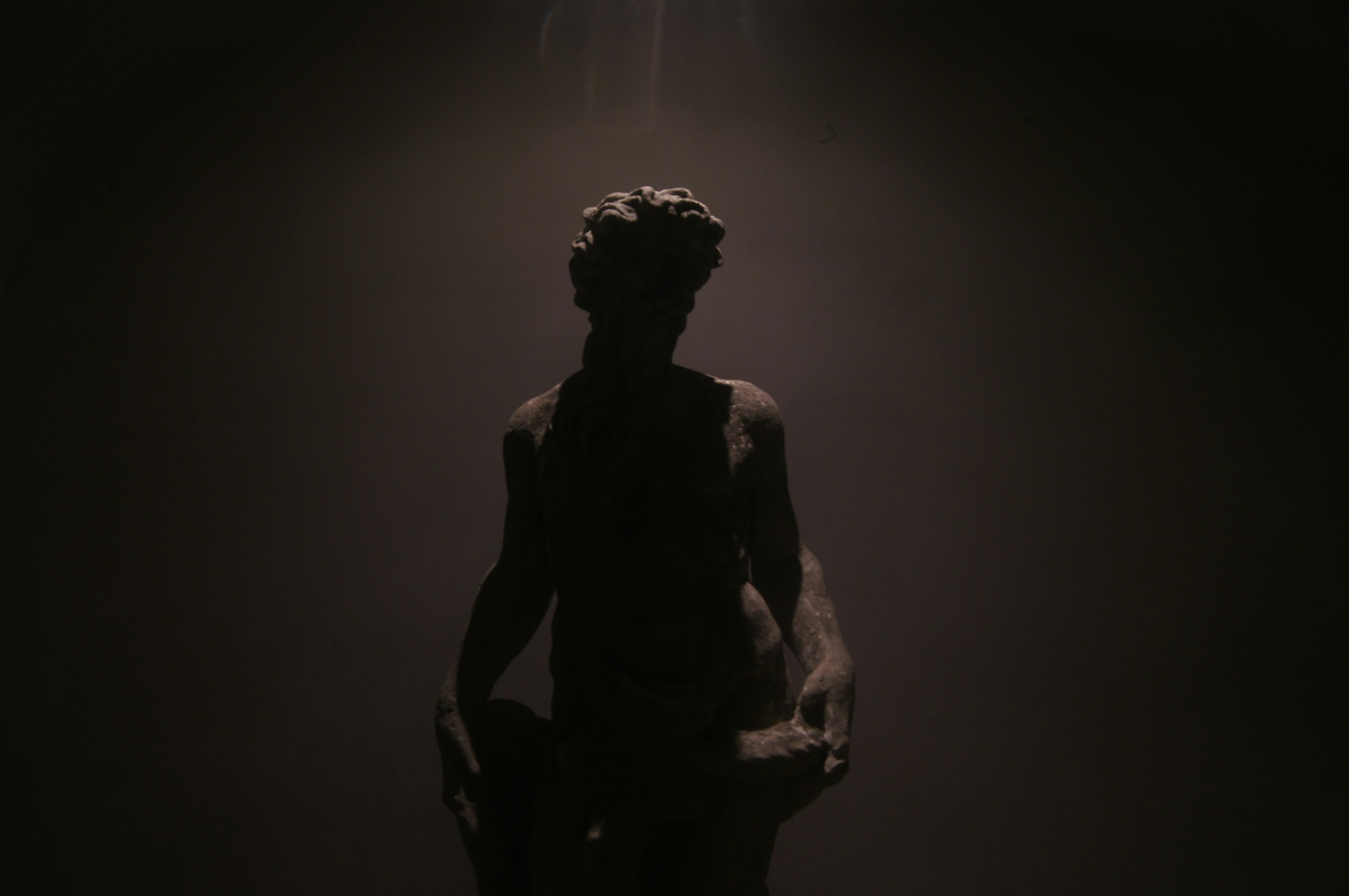Silhouette in the Spotlight: A Quiet Figure Emerging from Darkness