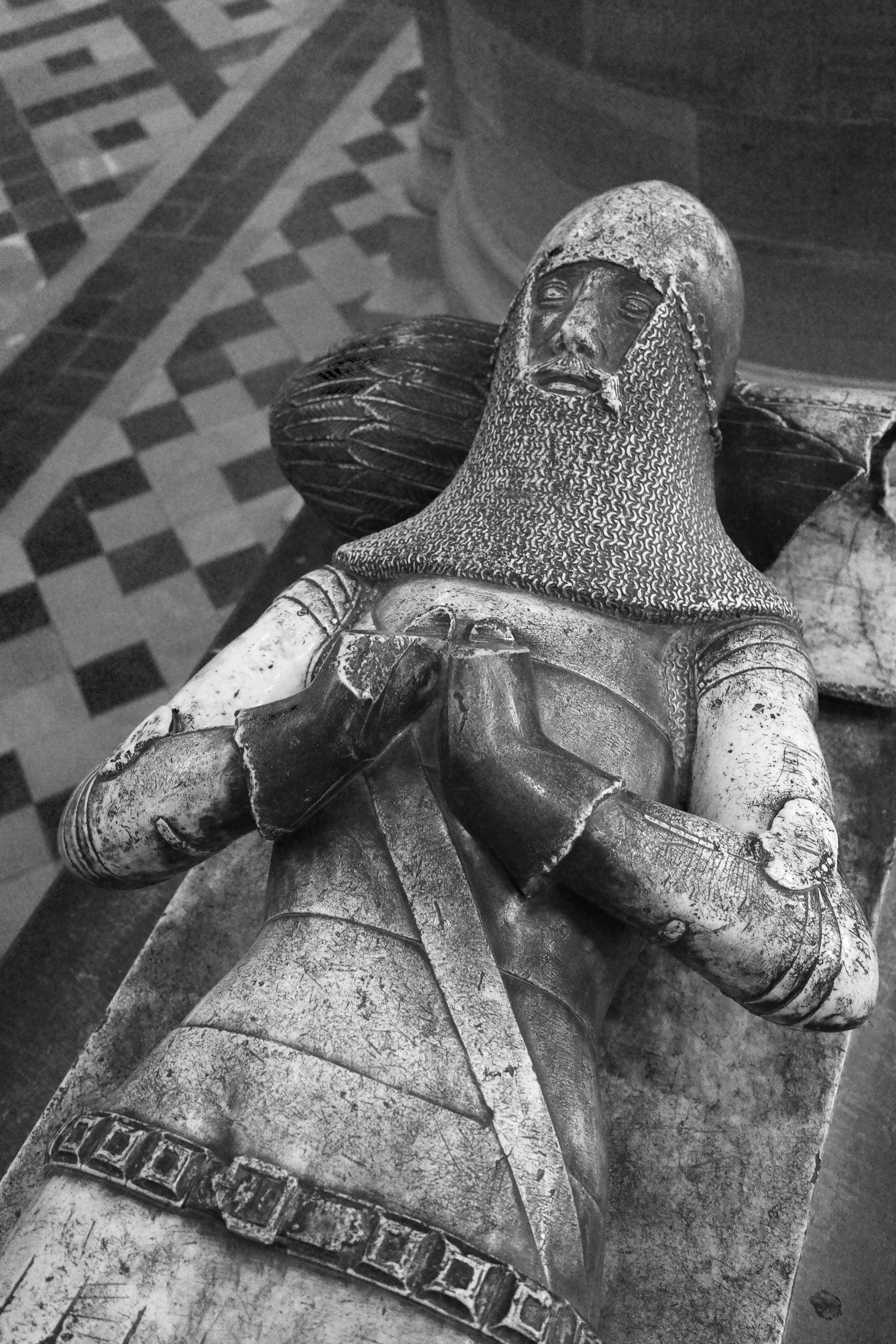 Stone effigy of a medieval knight in armor.