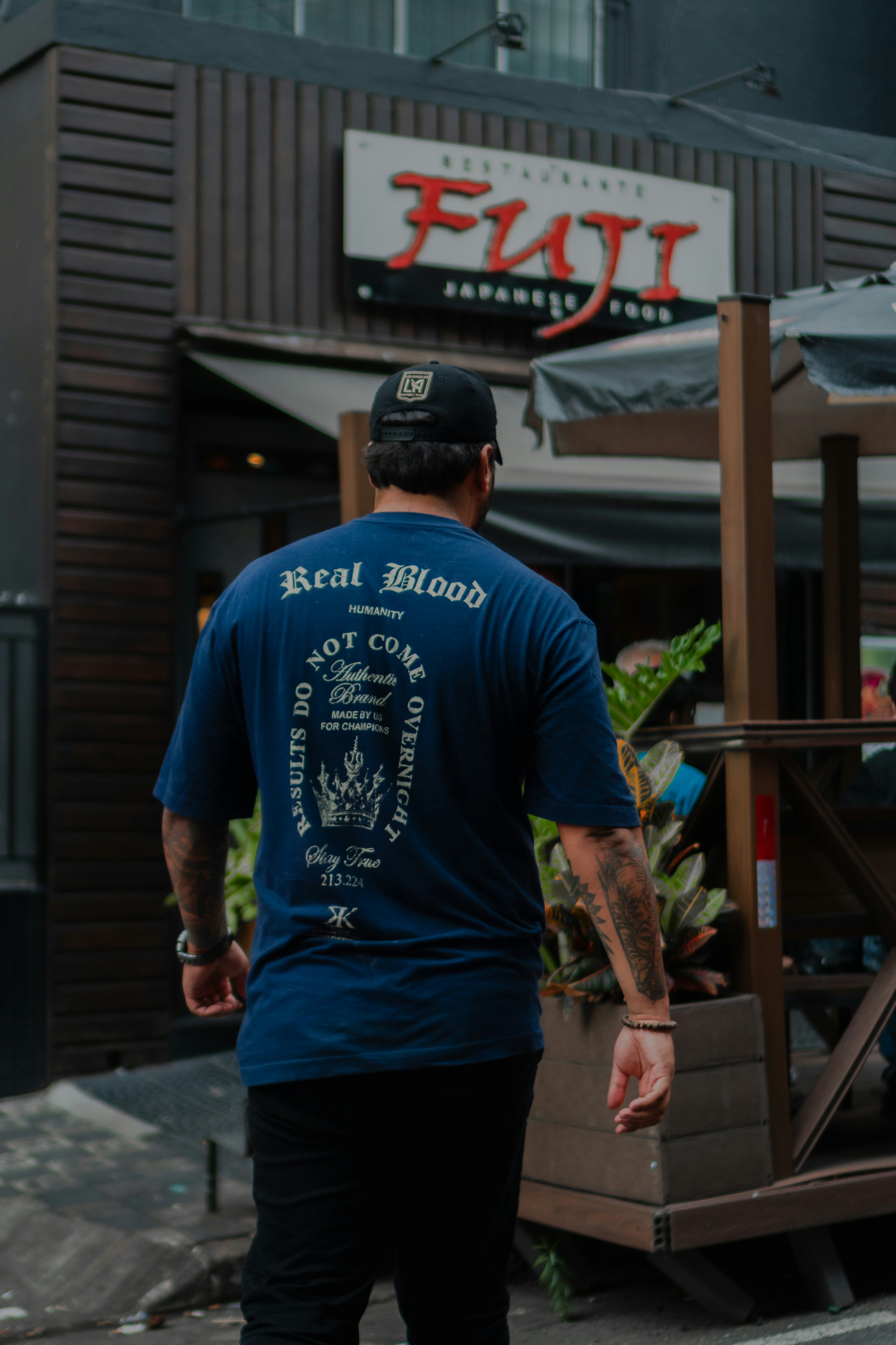 Blue-clad Foreman Walks Past a Restaurant Sign