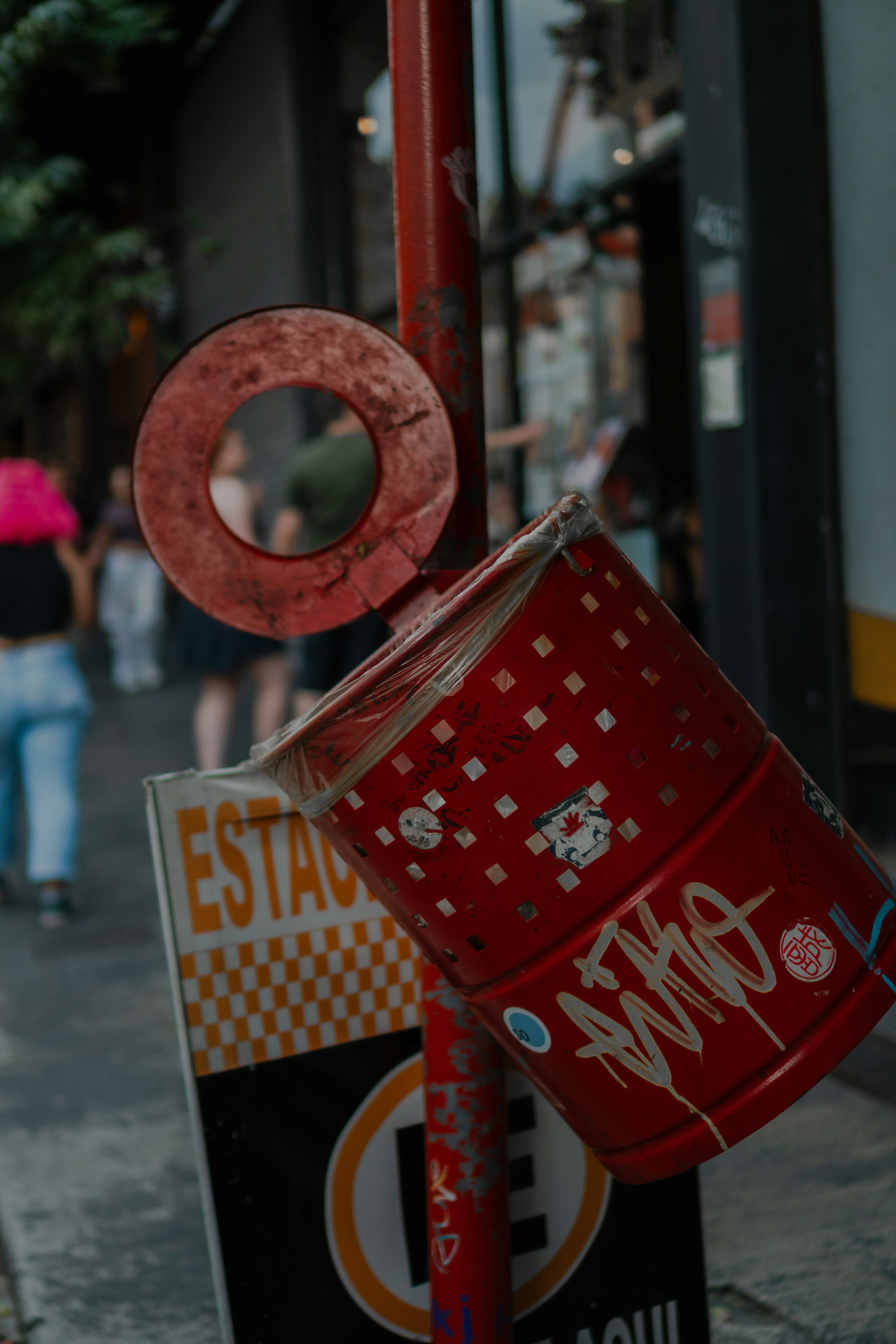 Rusted Red Drum and Circular Guardrail in a Gritty Street Scene