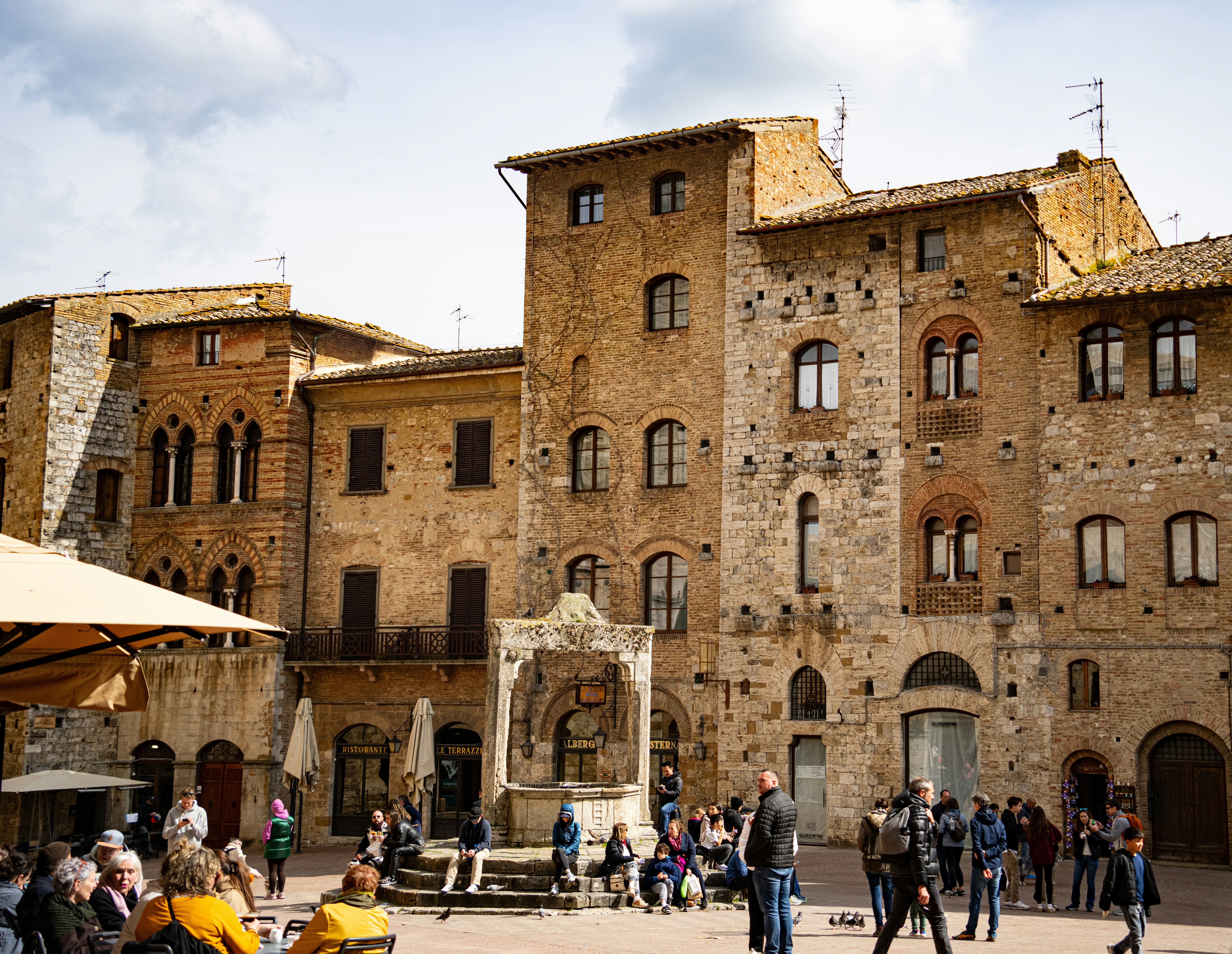 Stone Courtyard Rendezvous: A Medieval Piazza Amid Busy Tourists