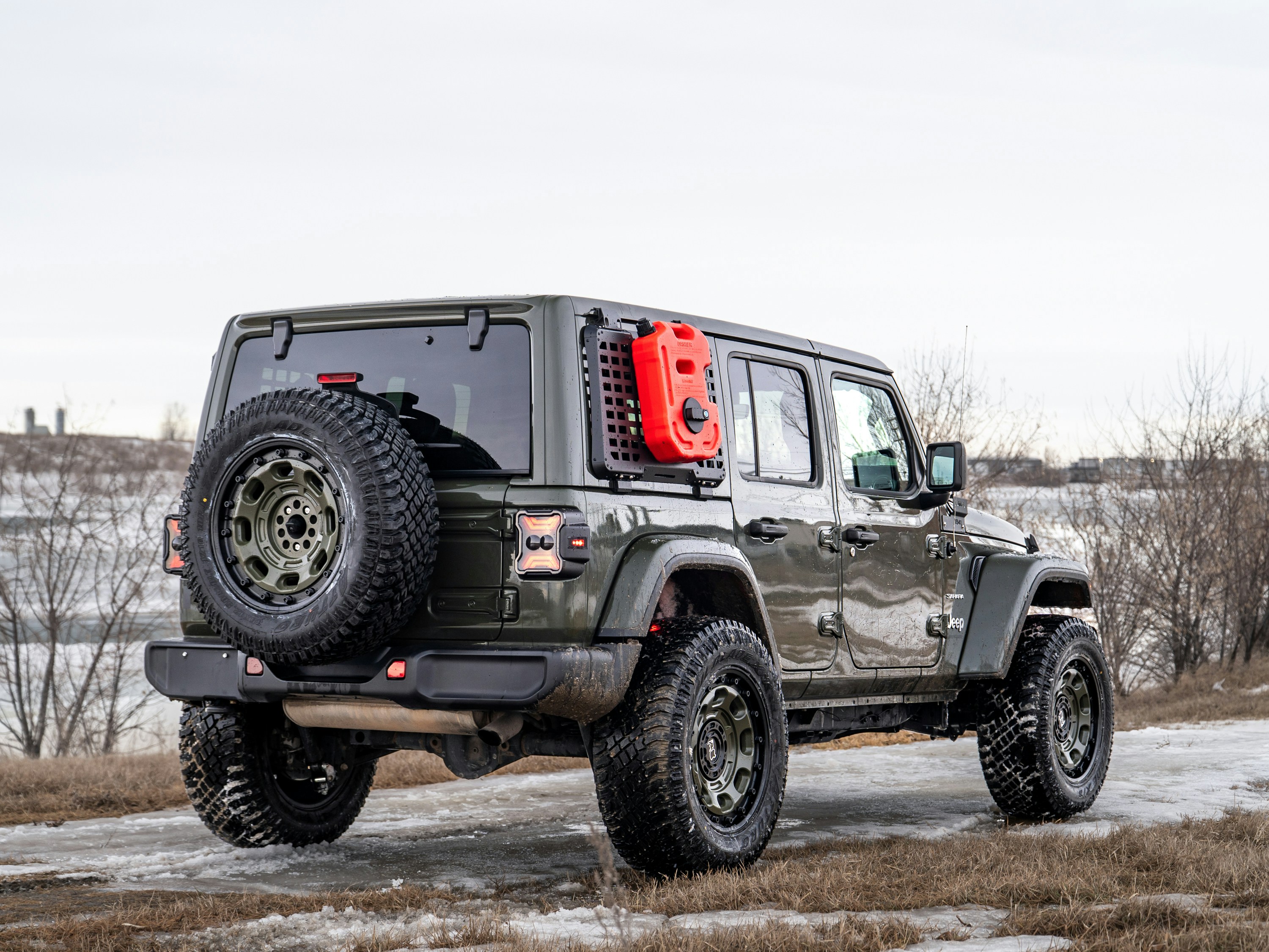 All-Terrain Sentinal: A Black Jeep Wrangler Poised on Wet Rutted Trail