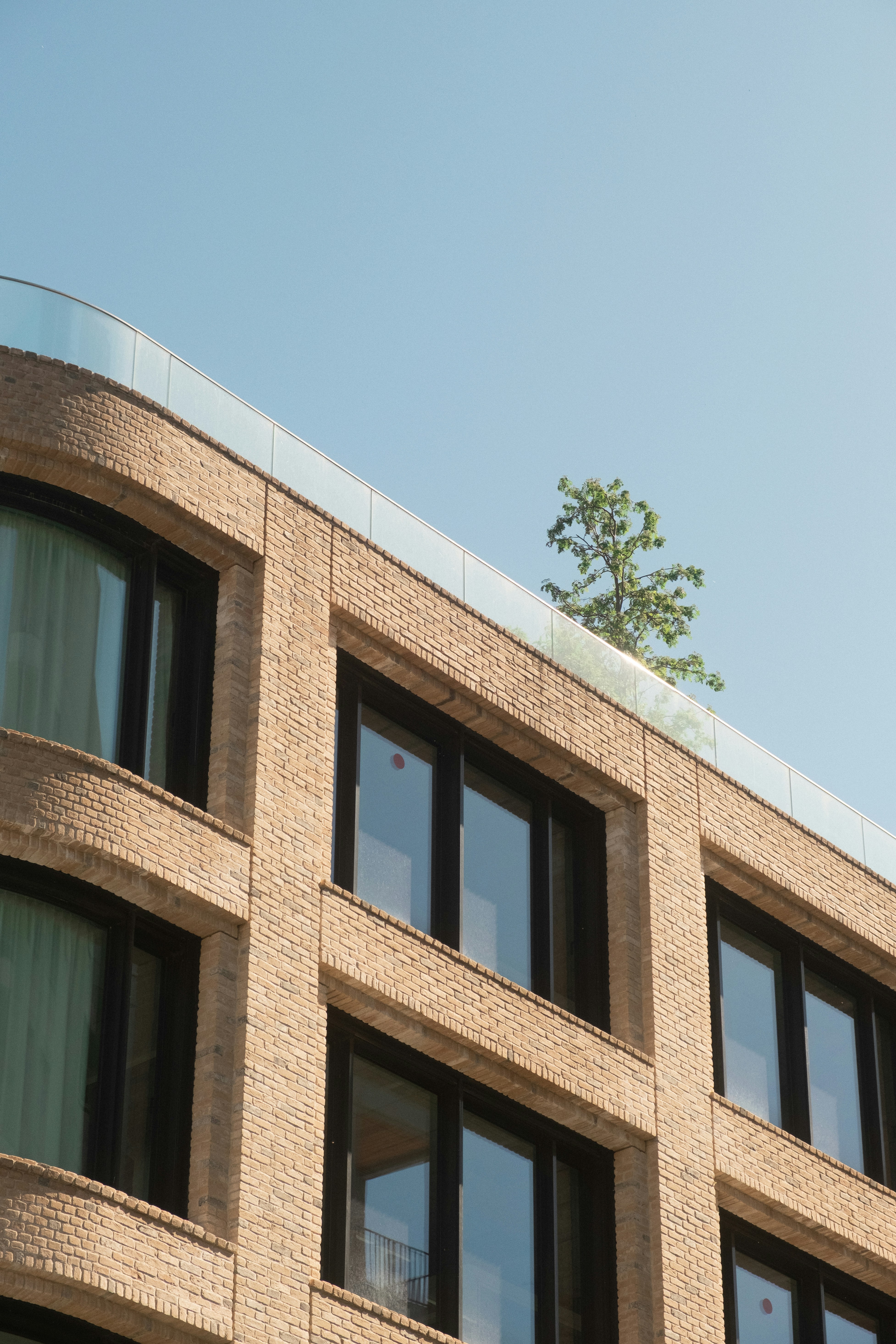 Brick Facade and Sky: A Modern Balcony Edge Under Clear Daylight