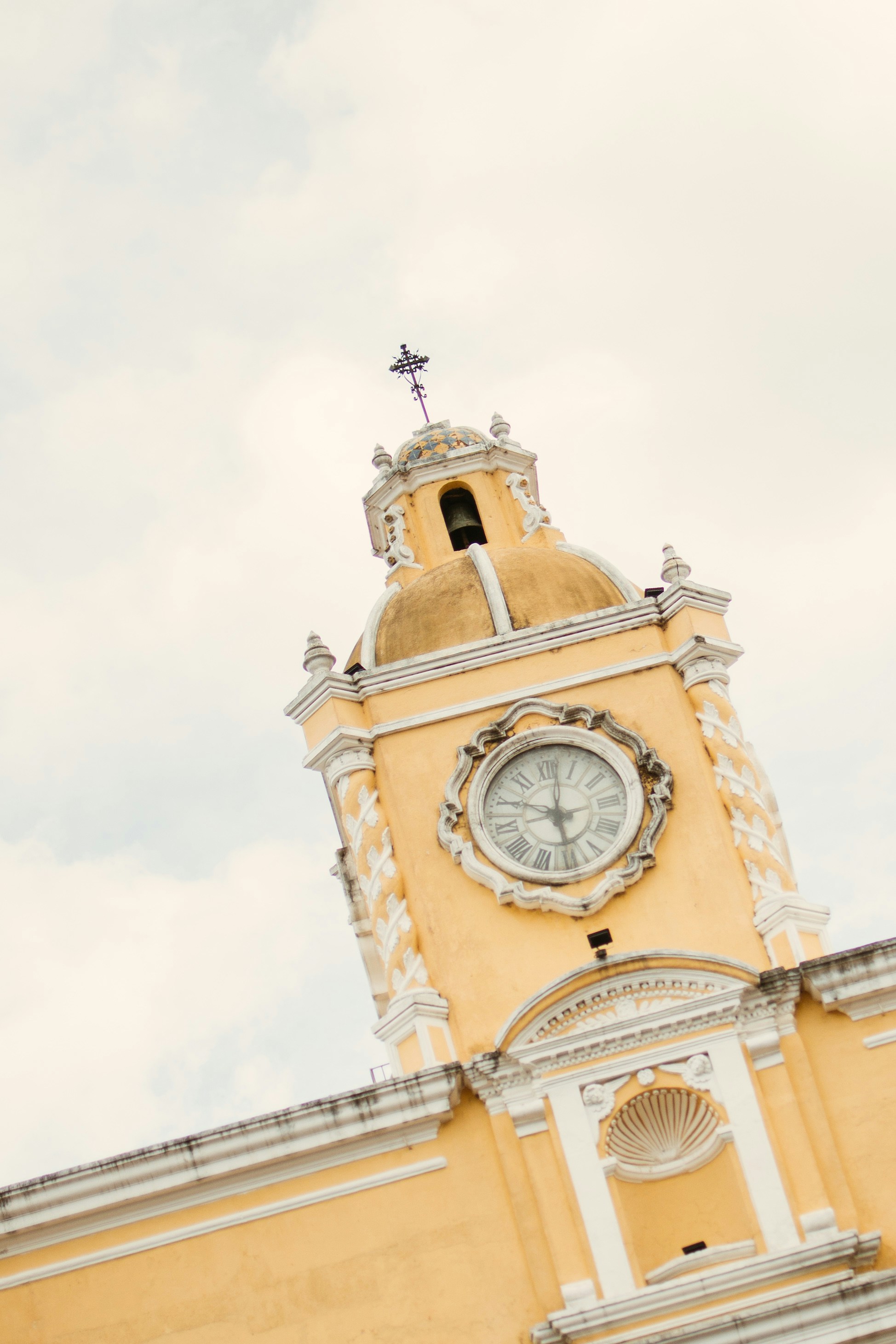 Sunlit Clocktower in Warm Yellow: A Tilted View Upward