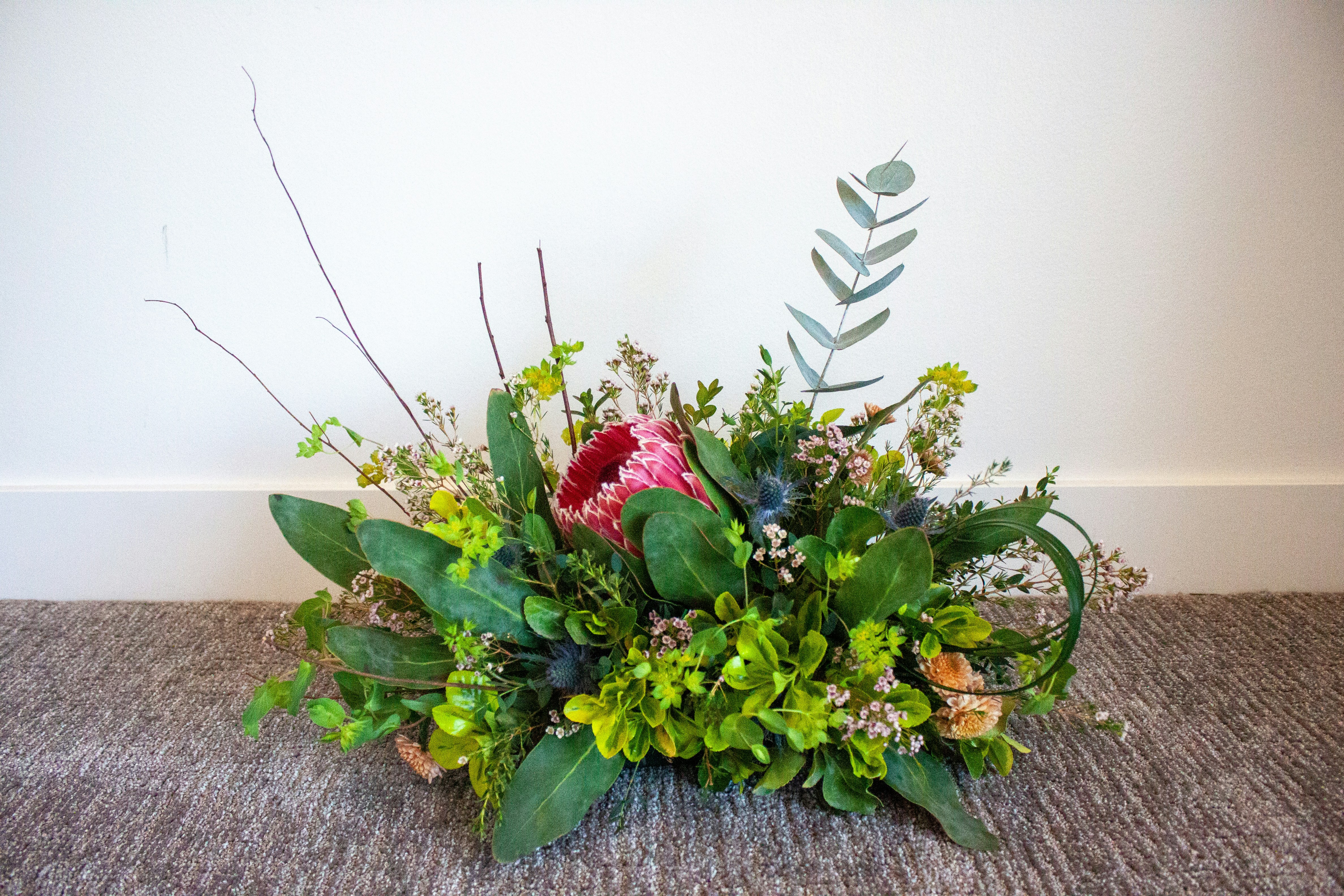 Low Bouquet, Quiet Corner: A Lush Centerpiece Resting on Carpeted Floor
