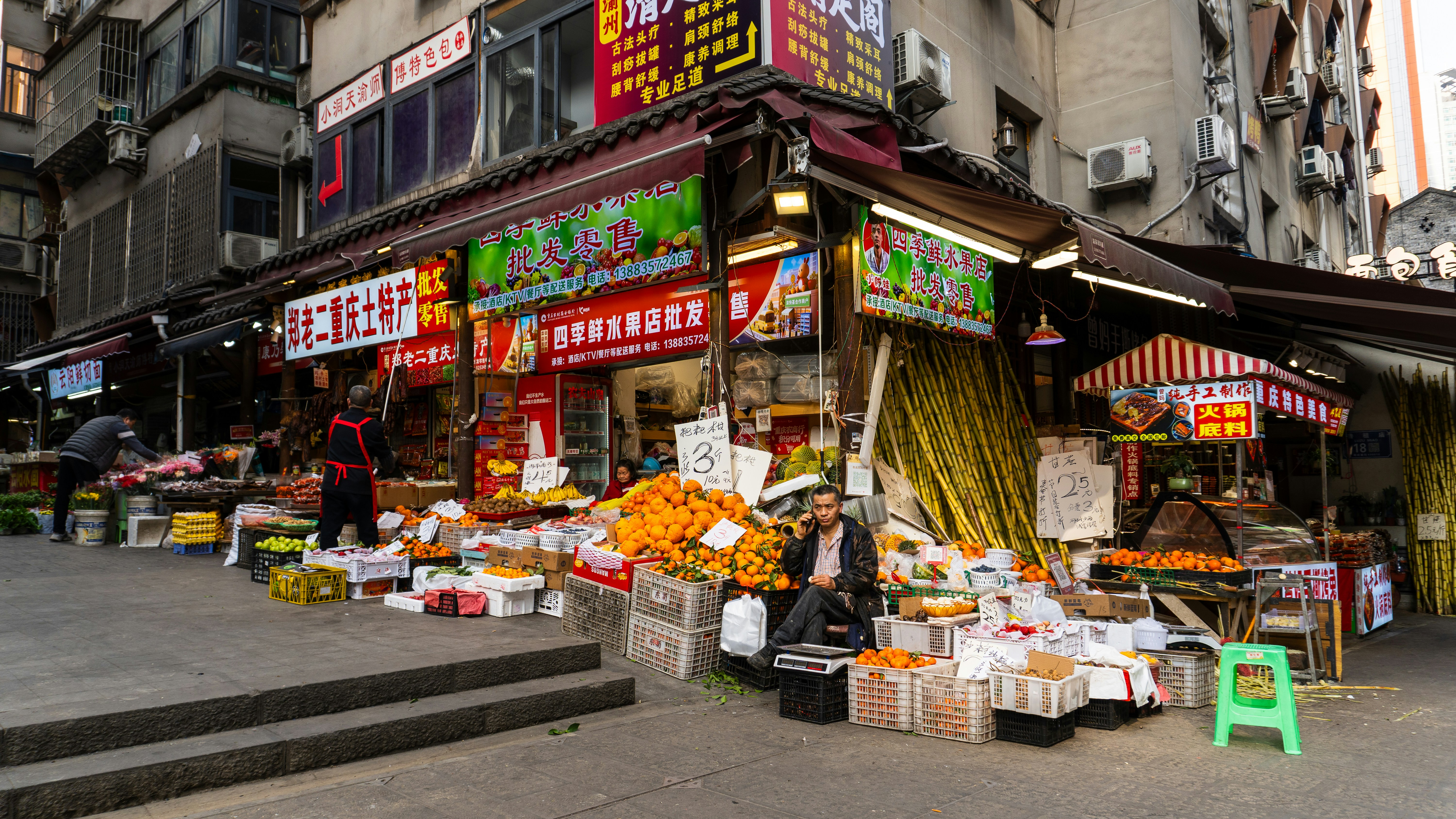 Vibrant Street Fruit Market Beneath Neon Bargain Signs