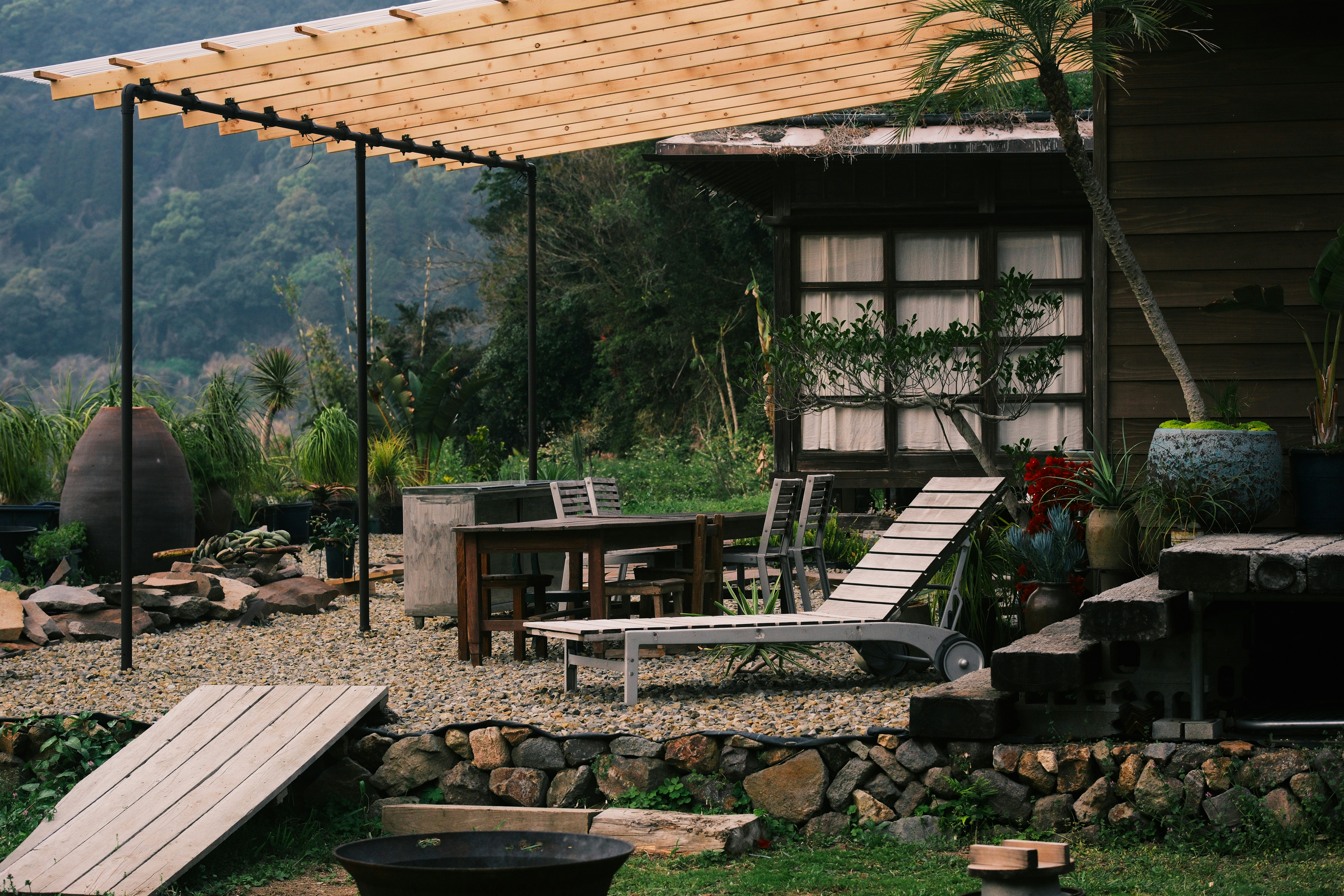 Tropical retreat with shaded terrace and lounge by a stone-terraced yard