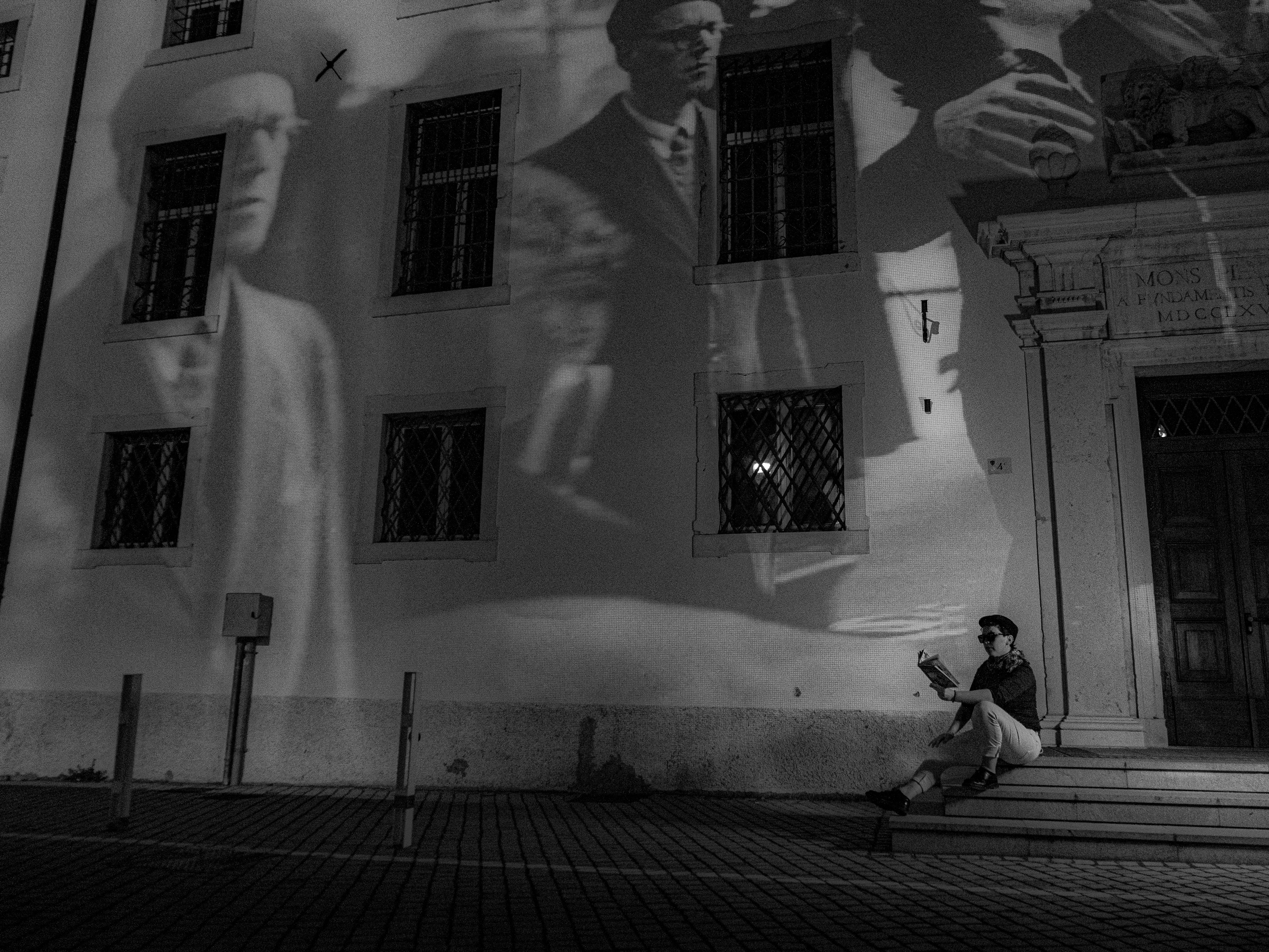 Shadows on the Facade: A Quiet Moment Amid Projected Echoes