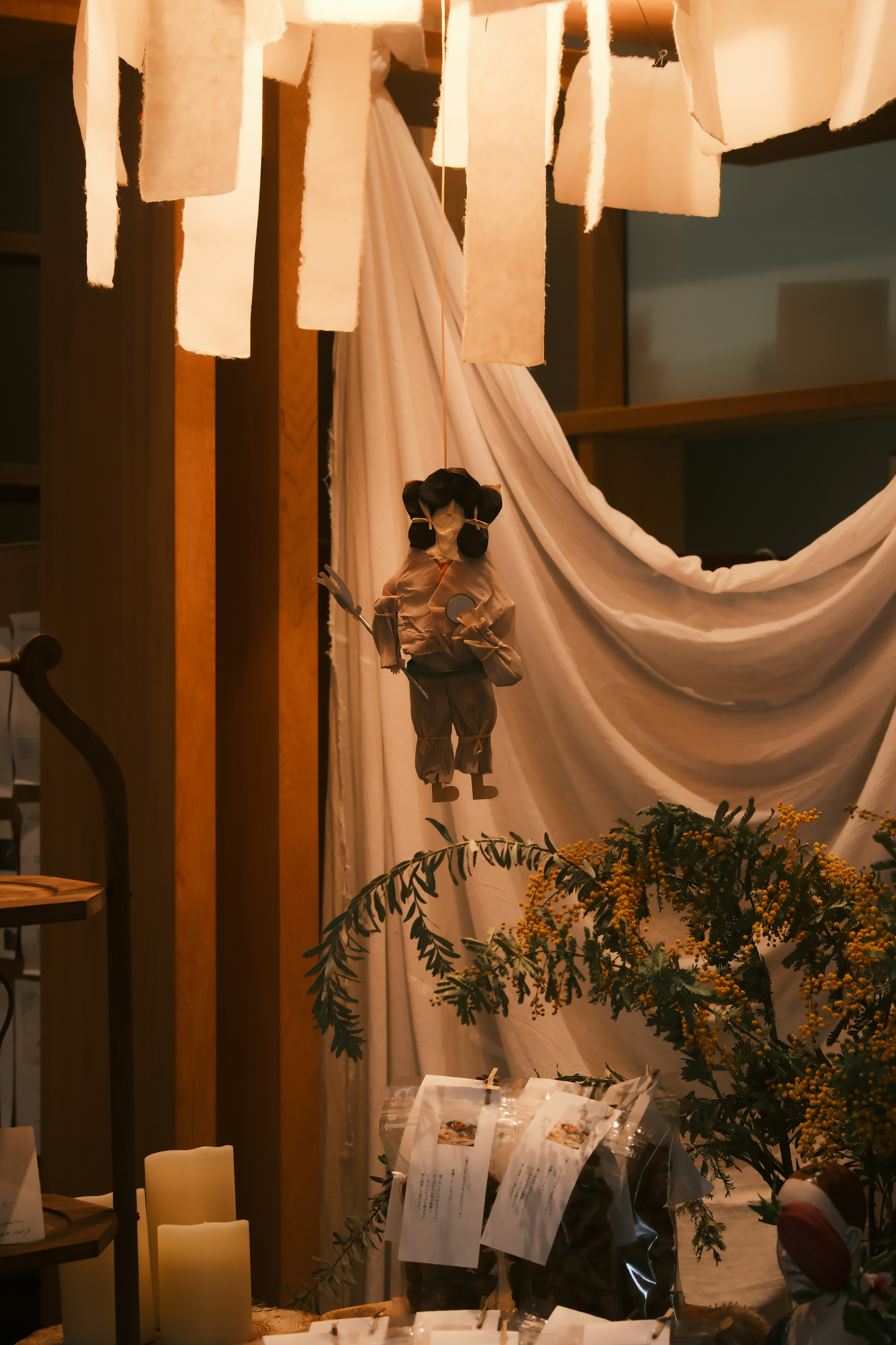 Suspended Bearer: A Plush Figure Hovering Over a Floral Altar