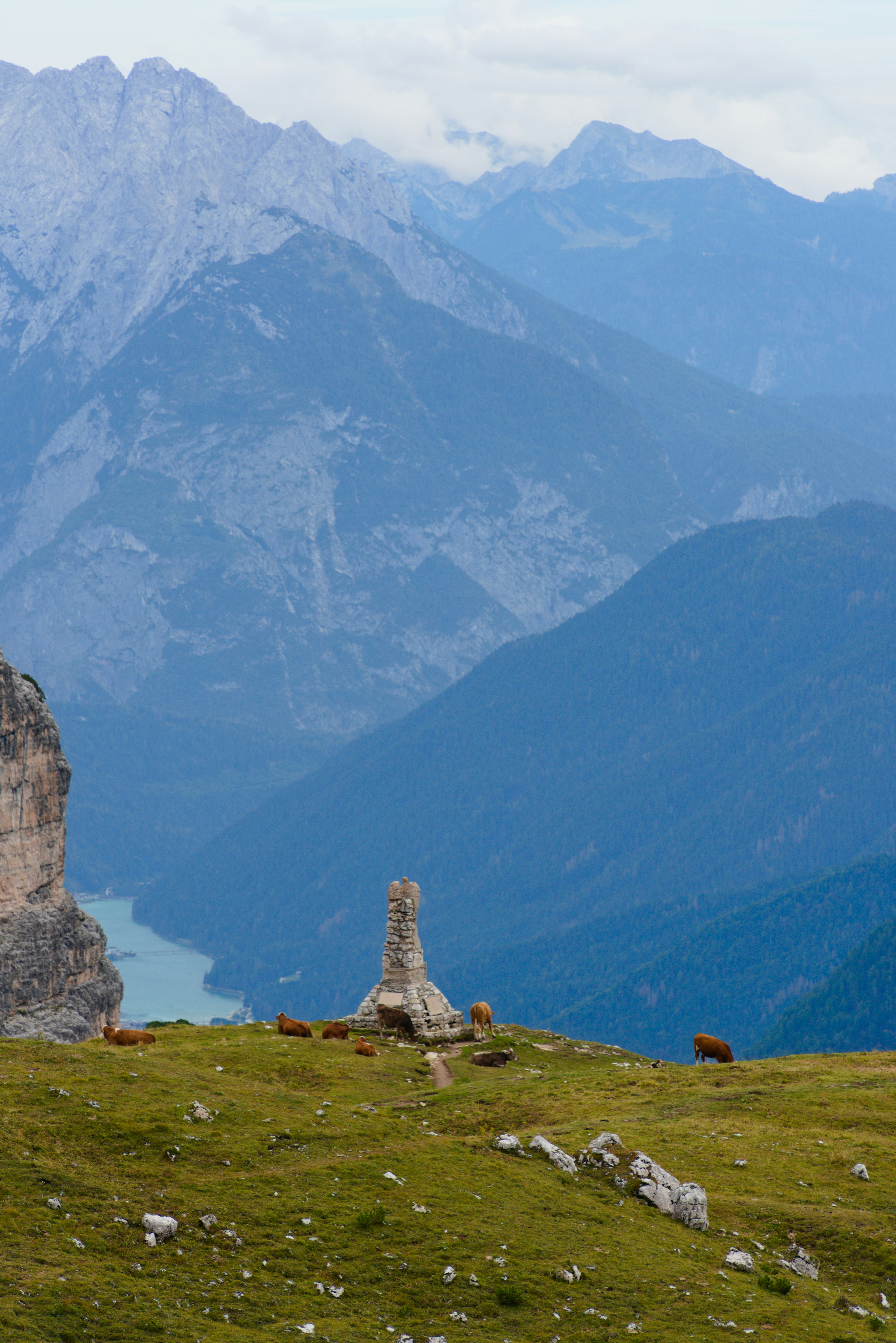 Cows graze near a monument on a mountain ridge. photo – Free Travel ...