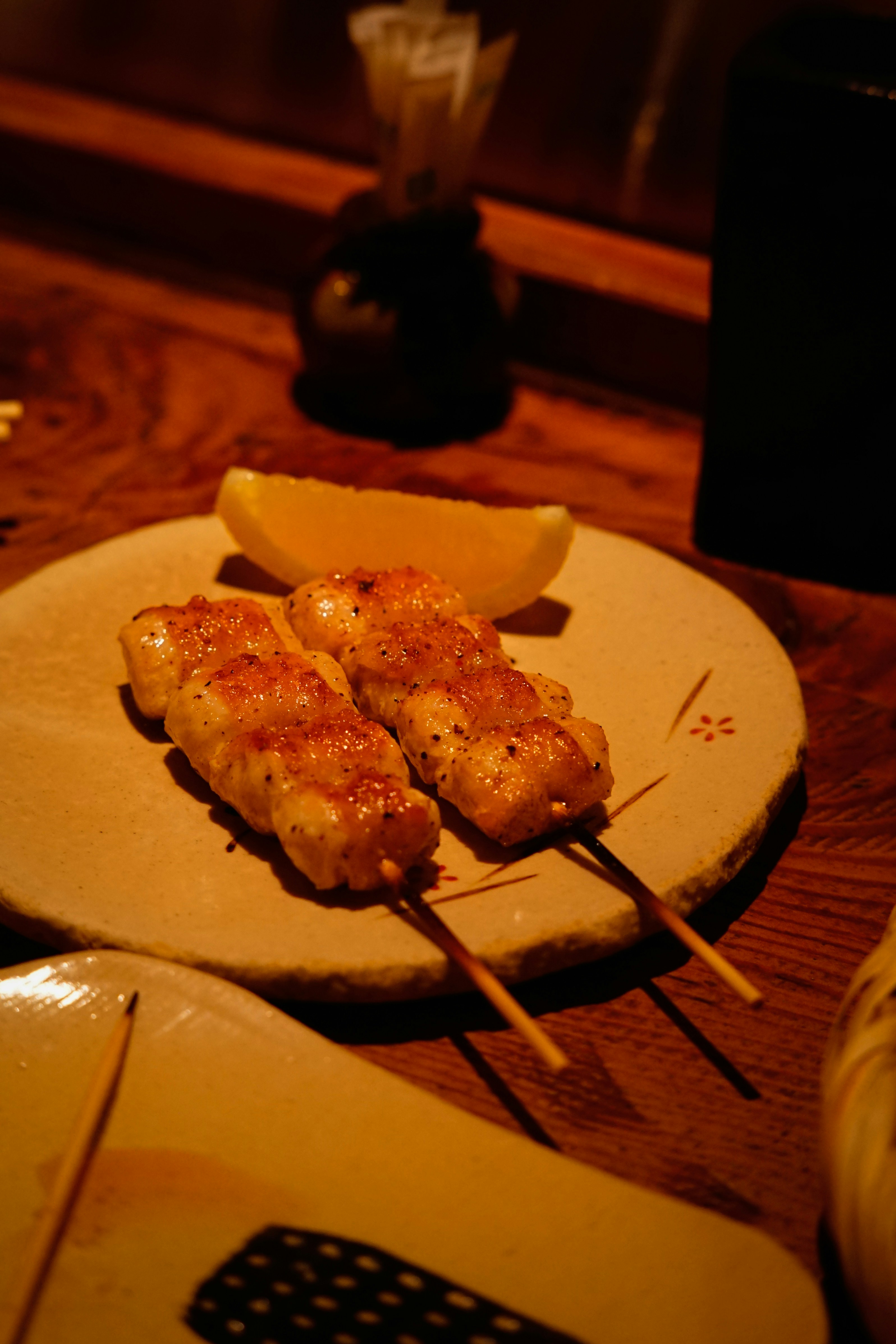 Charred Yakitori on a Stone Platter with Lemon Wedge