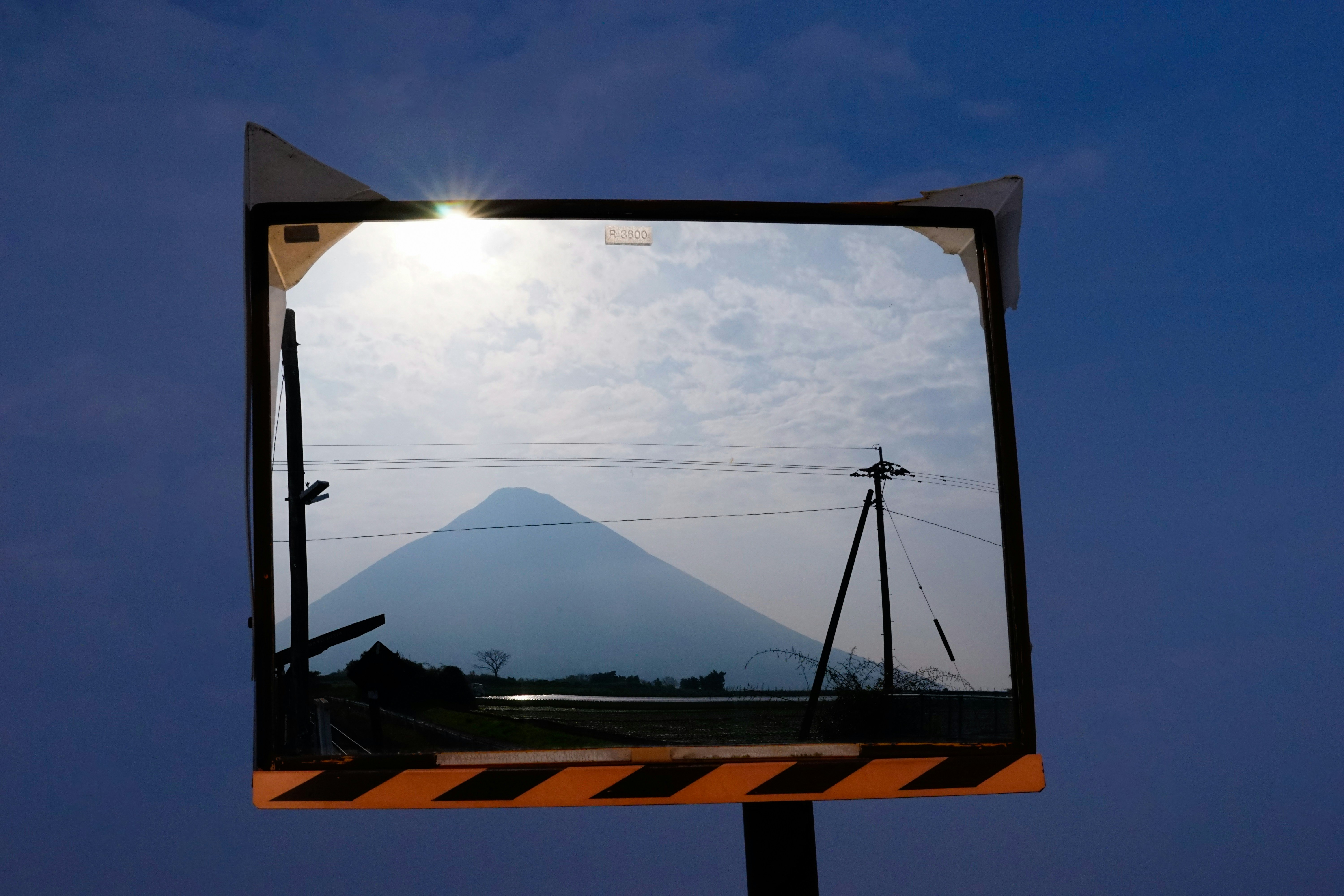 Silhouette through a Frame: Mountaintop Scene Framed by a Warning Barrier