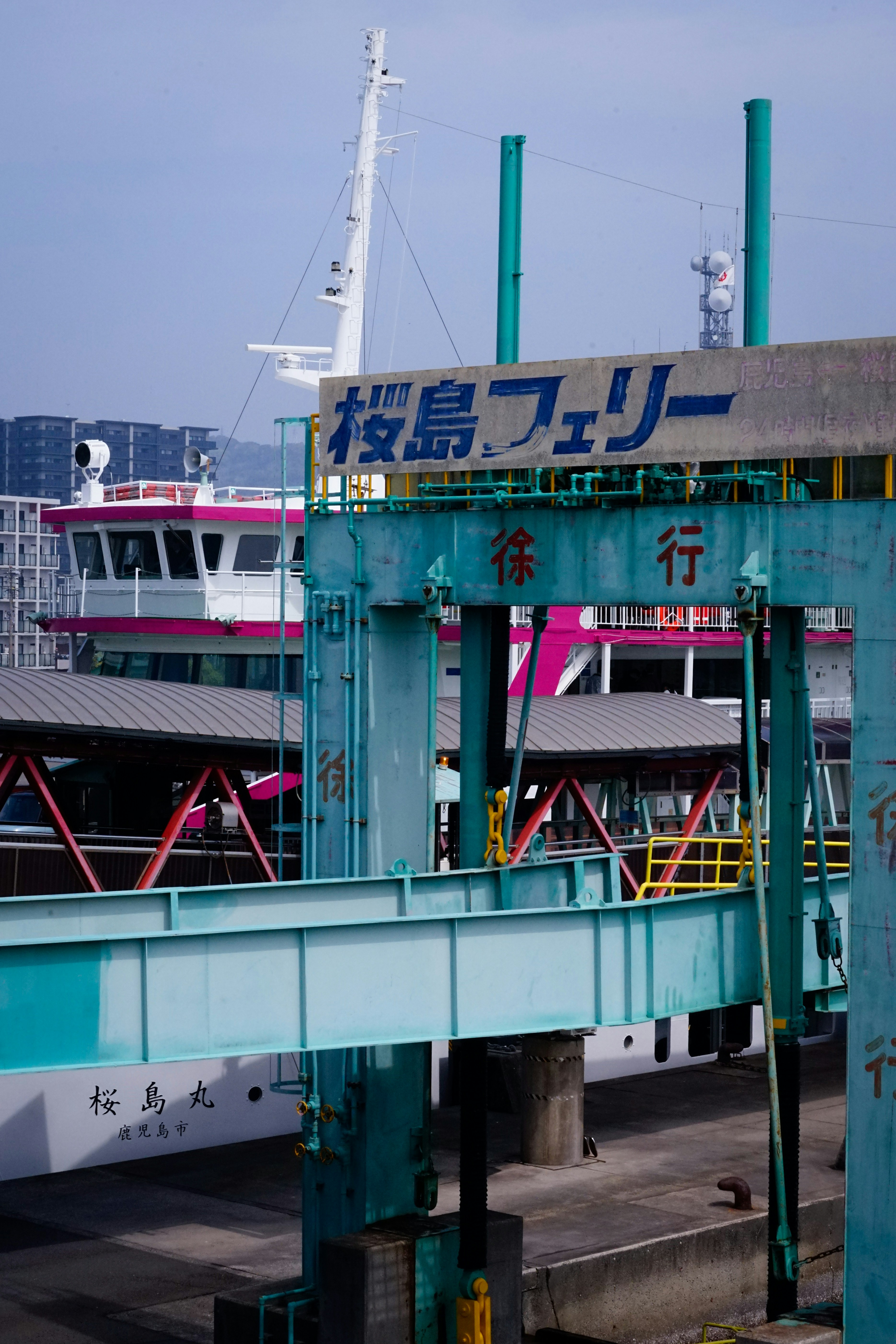 Harbor Gate: turquoise structure framing a docked ferry