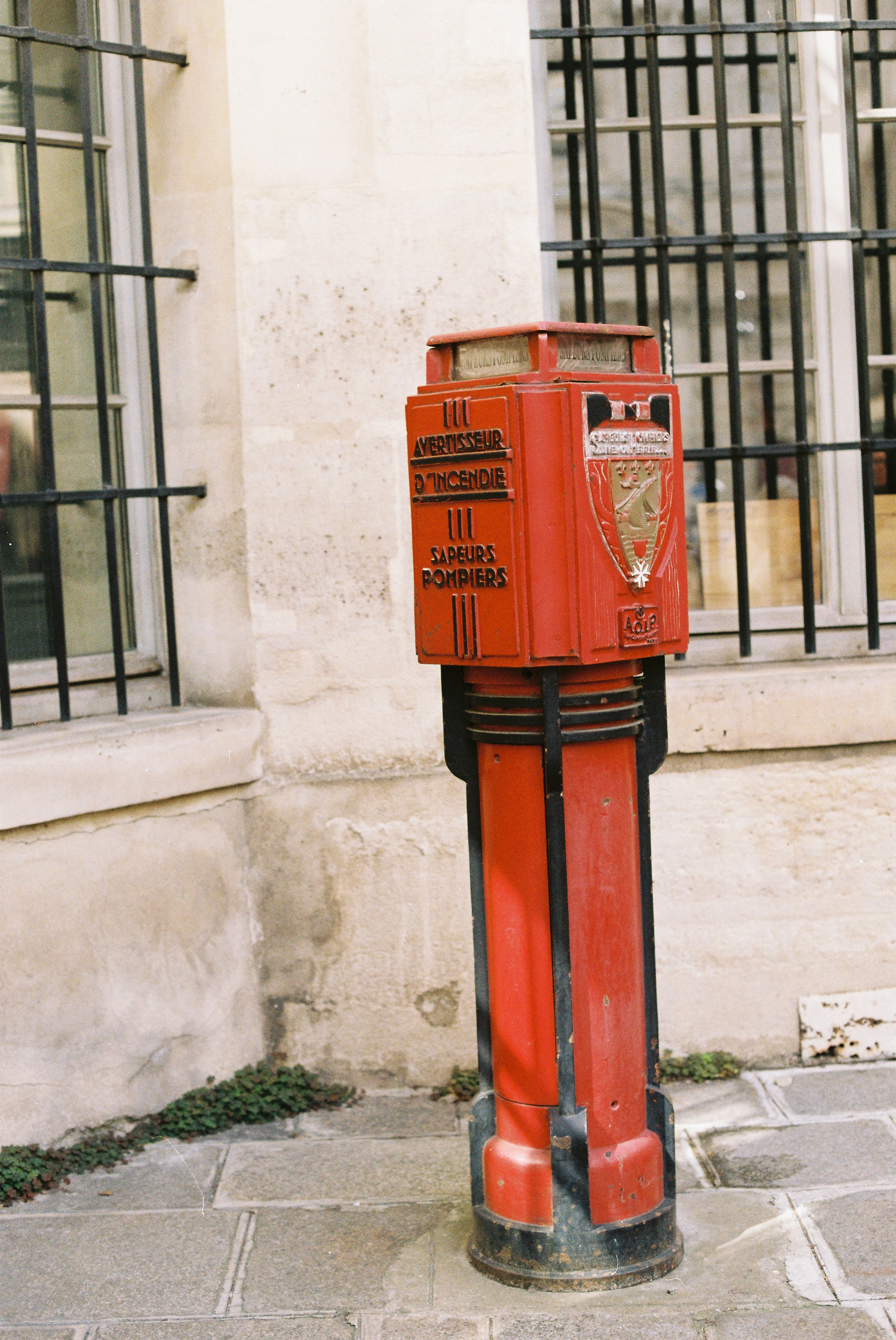 A red antique fire alarm post on a street. photo – Free Fire safety ...