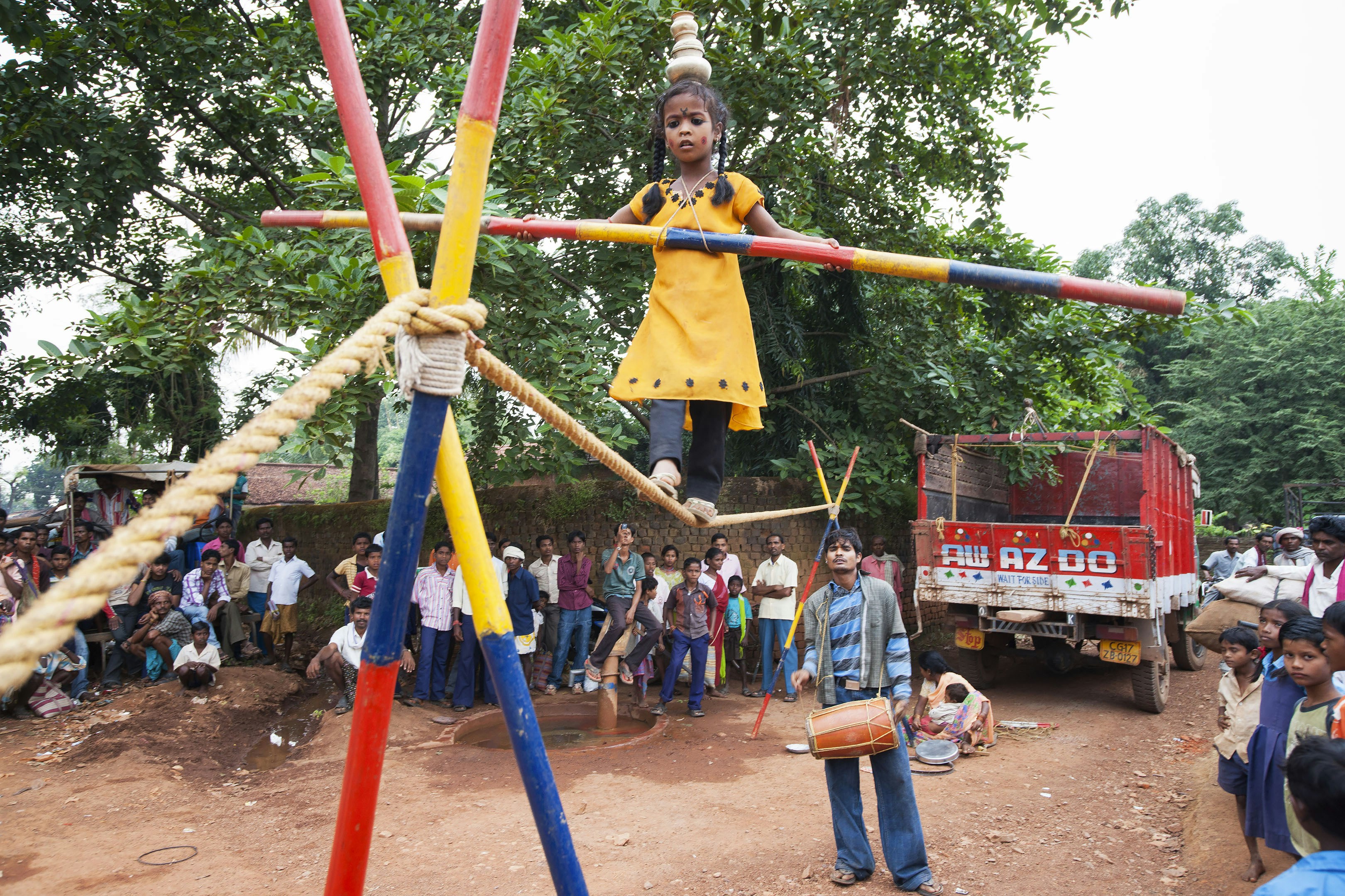 Balancing Act on the Saw-Tooth: A Girl in an Orange Dress on a Jungle Gym Habitat