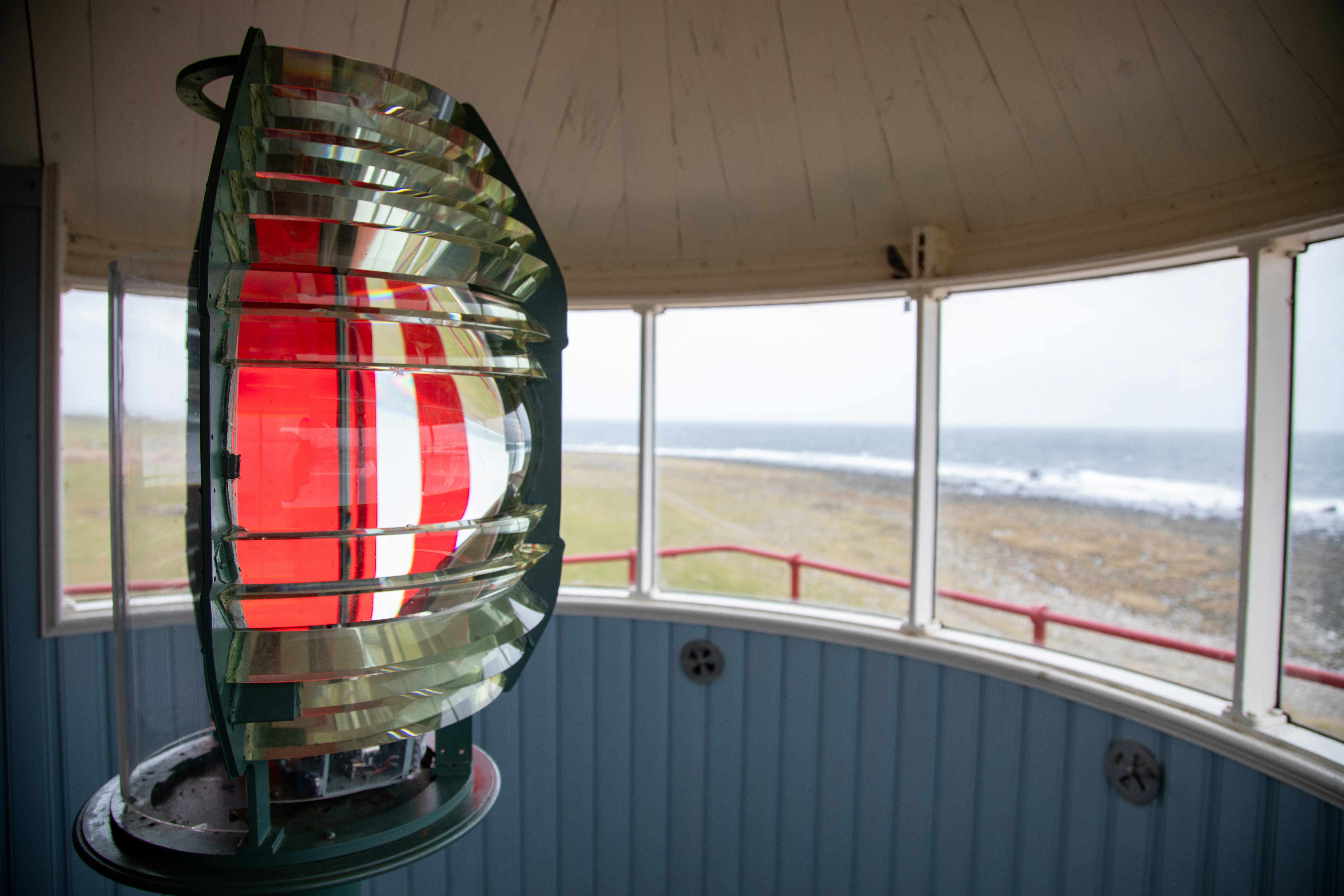 Glass Shards of Coastal Light: A Lighthouse Beacon Framed by Ocean Horizon