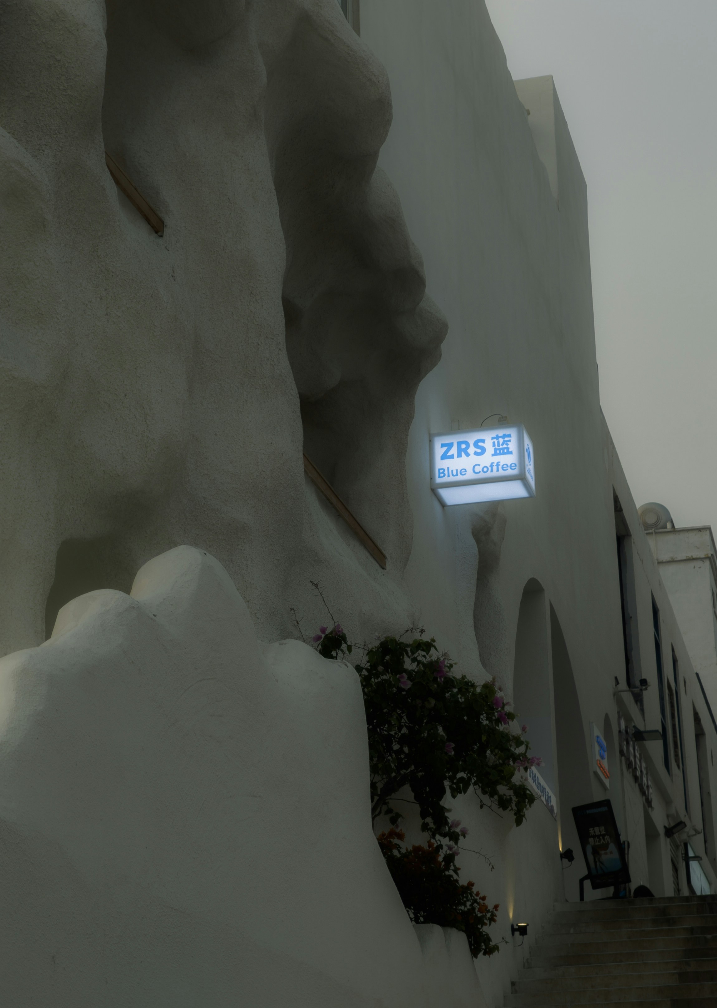 Blue Coffee Sign Beside Whitewashed Architecture