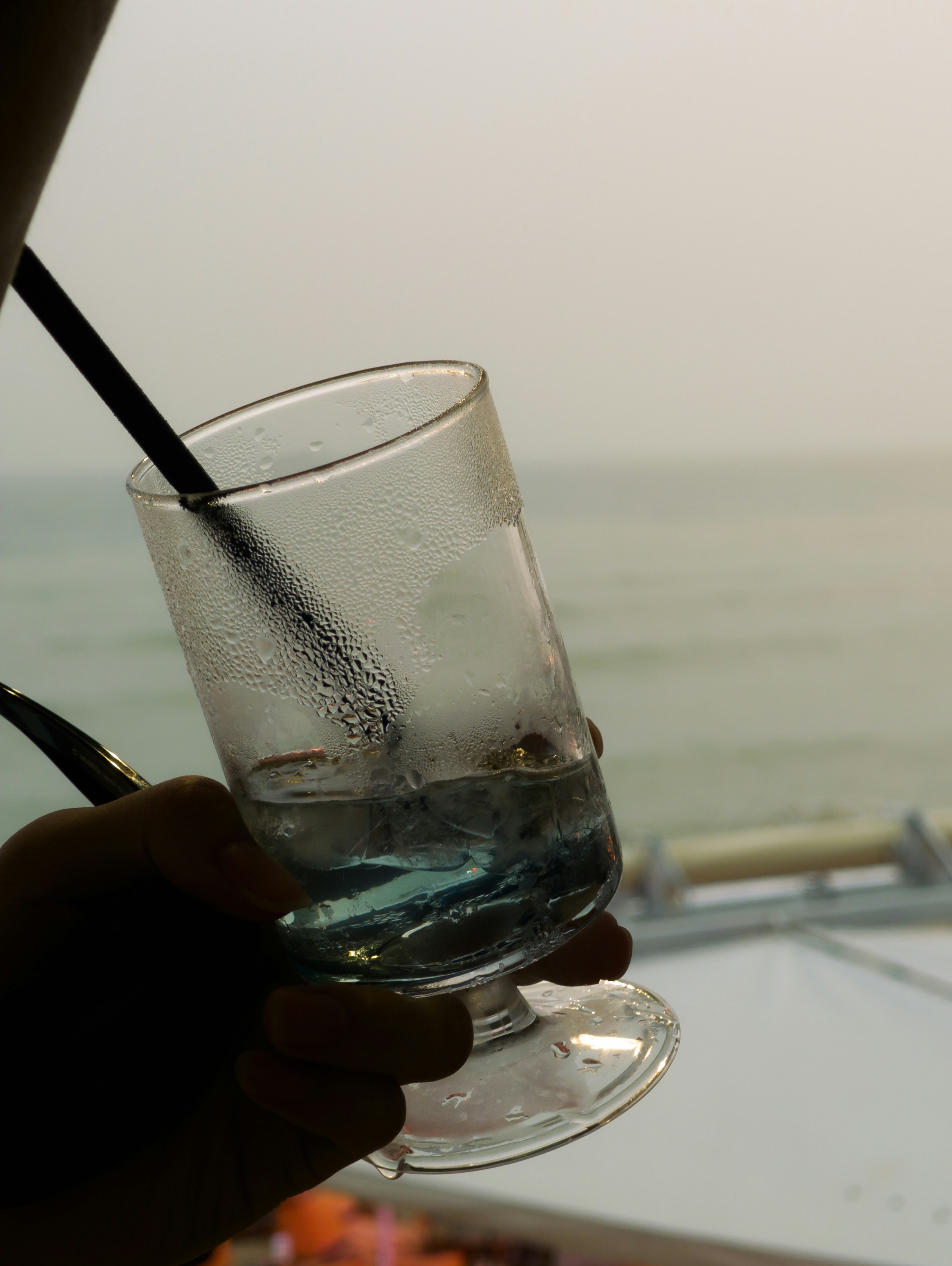 Relaxed toast at sea: a frosted glass caught in soft sunset light